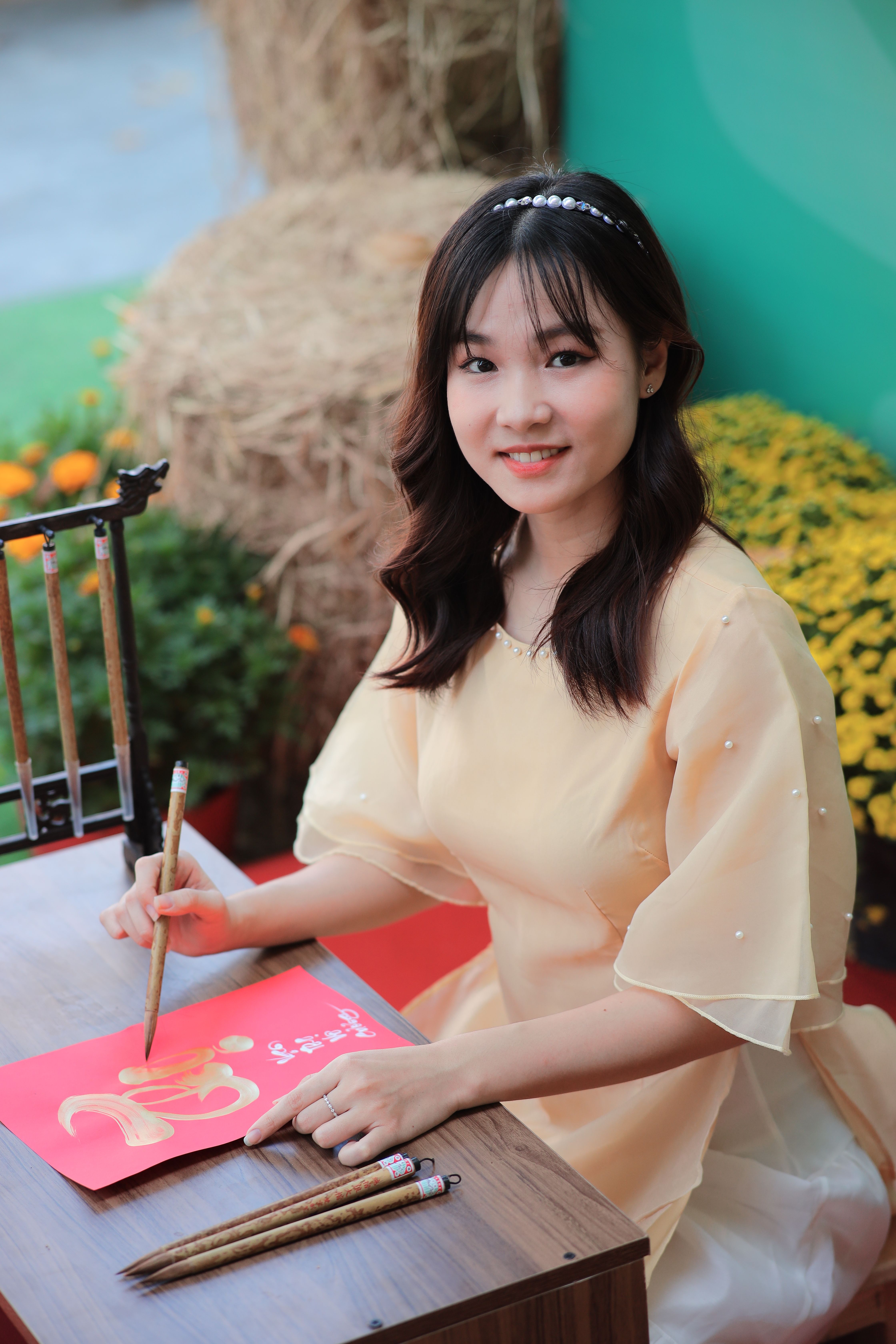 Smiling Young Model in a Cream Ao Dai Tunic Drawing Calligraphy · Free ...