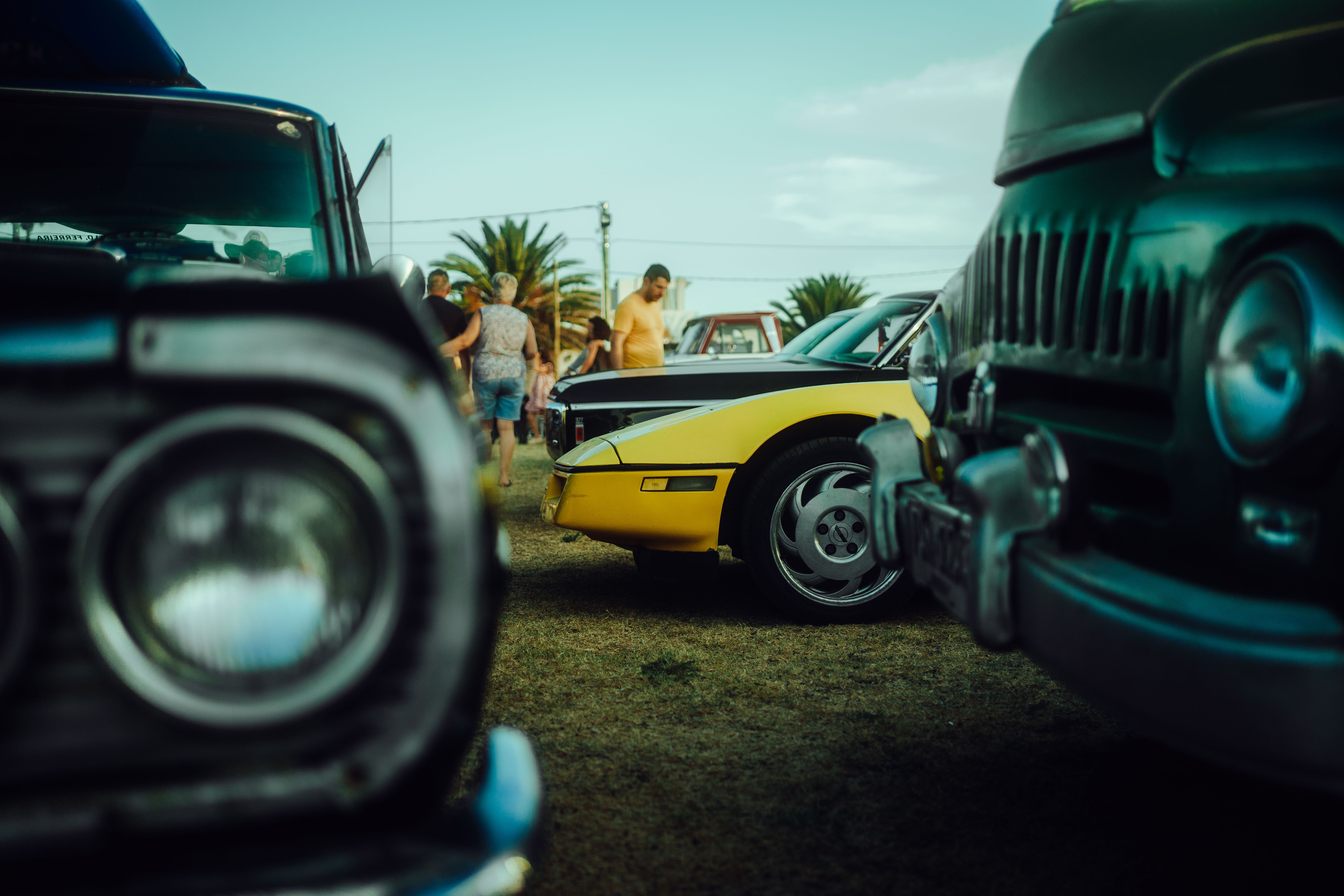 A group of people standing around a car · Free Stock Photo