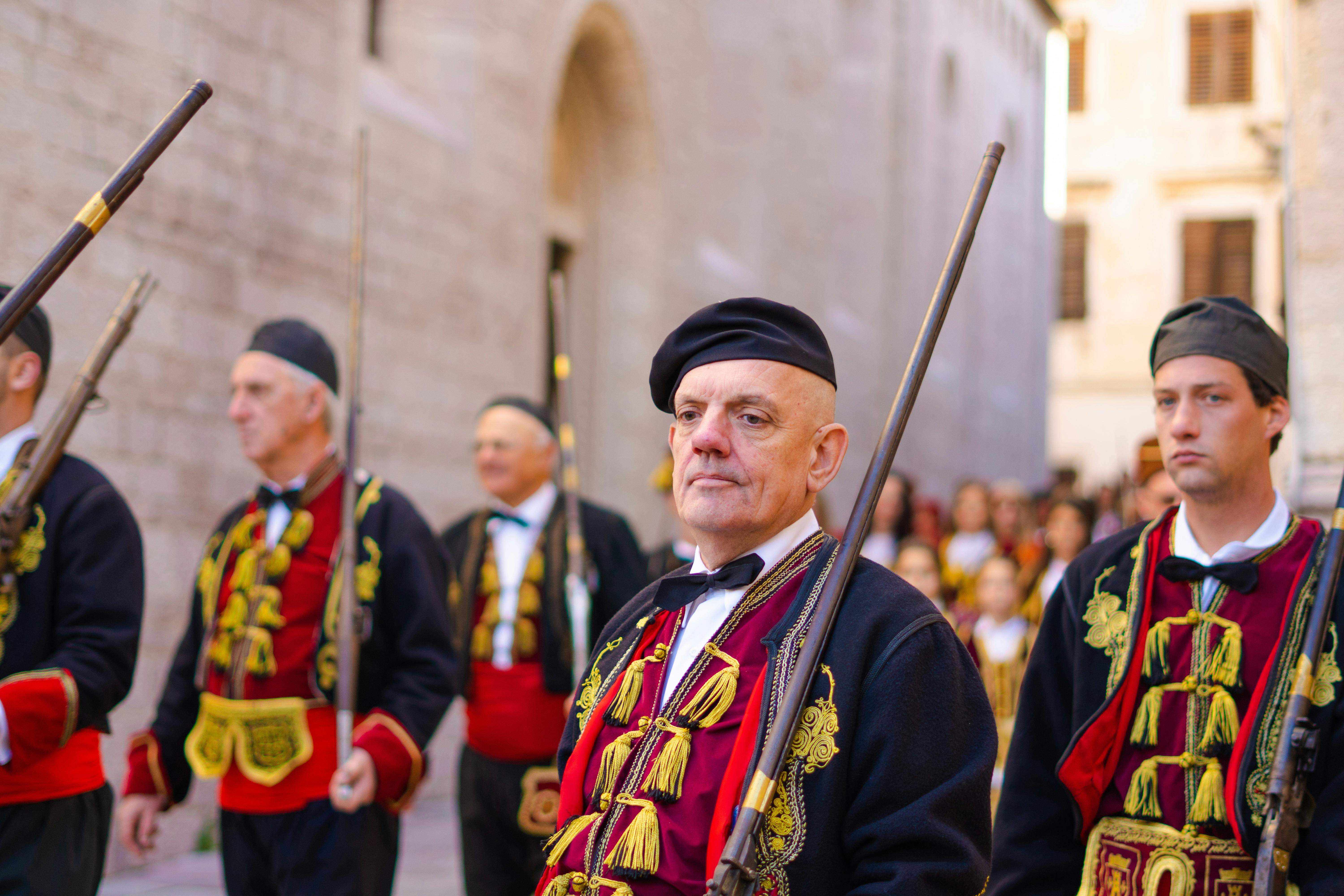 A group of men in traditional clothing holding rifles · Free Stock Photo