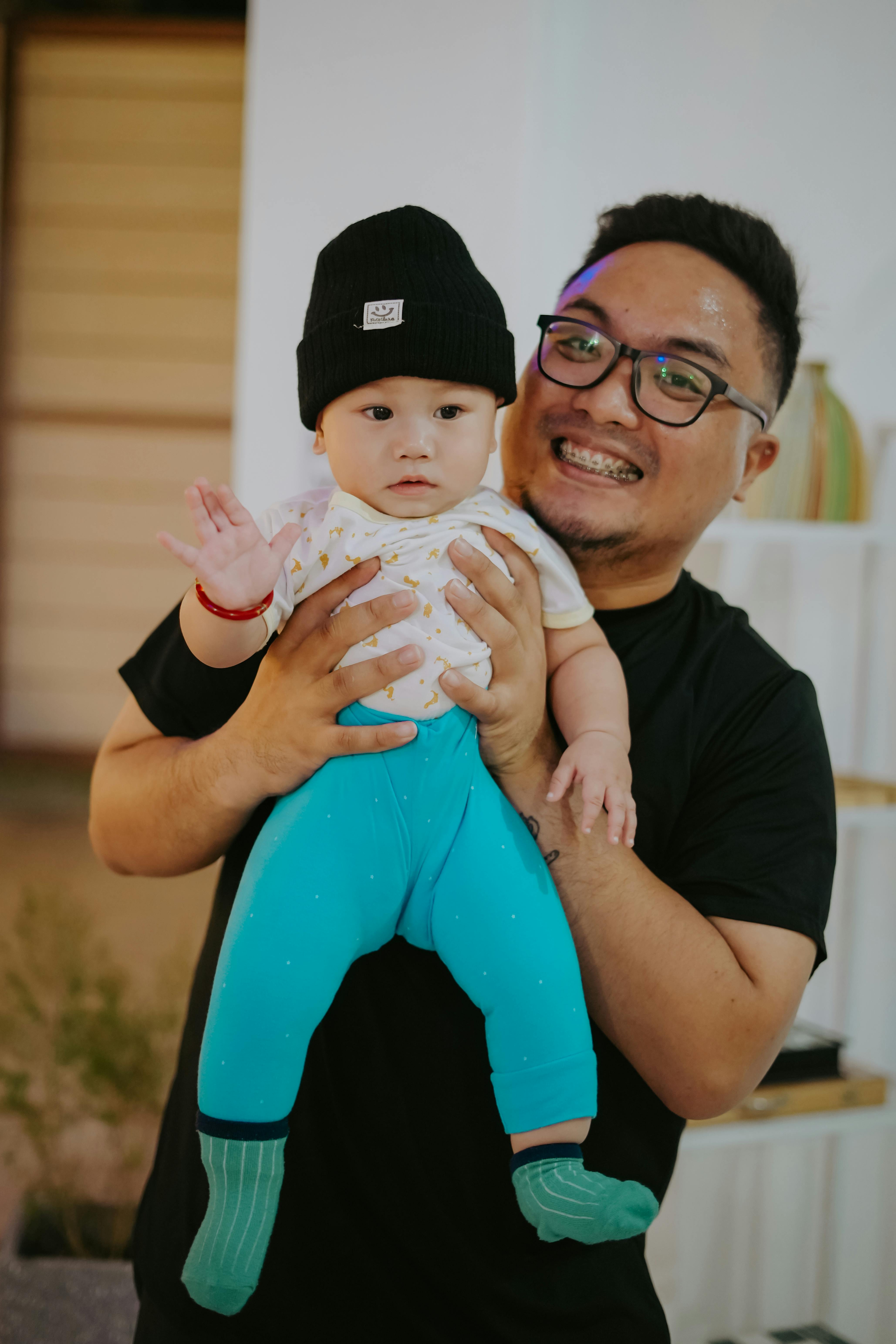 Smiling Man Holding Baby · Free Stock Photo