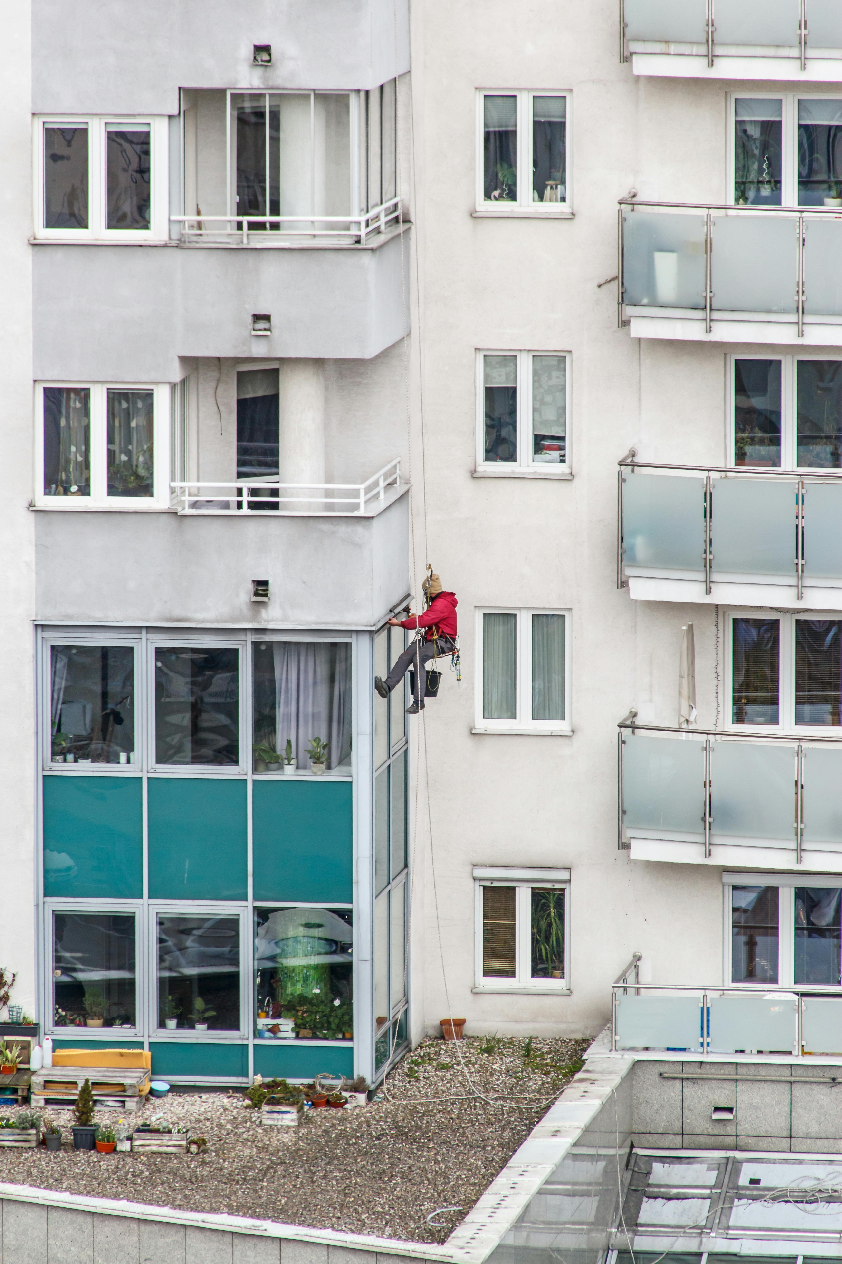 Man Working on Wall of Residential Building · Free Stock Photo