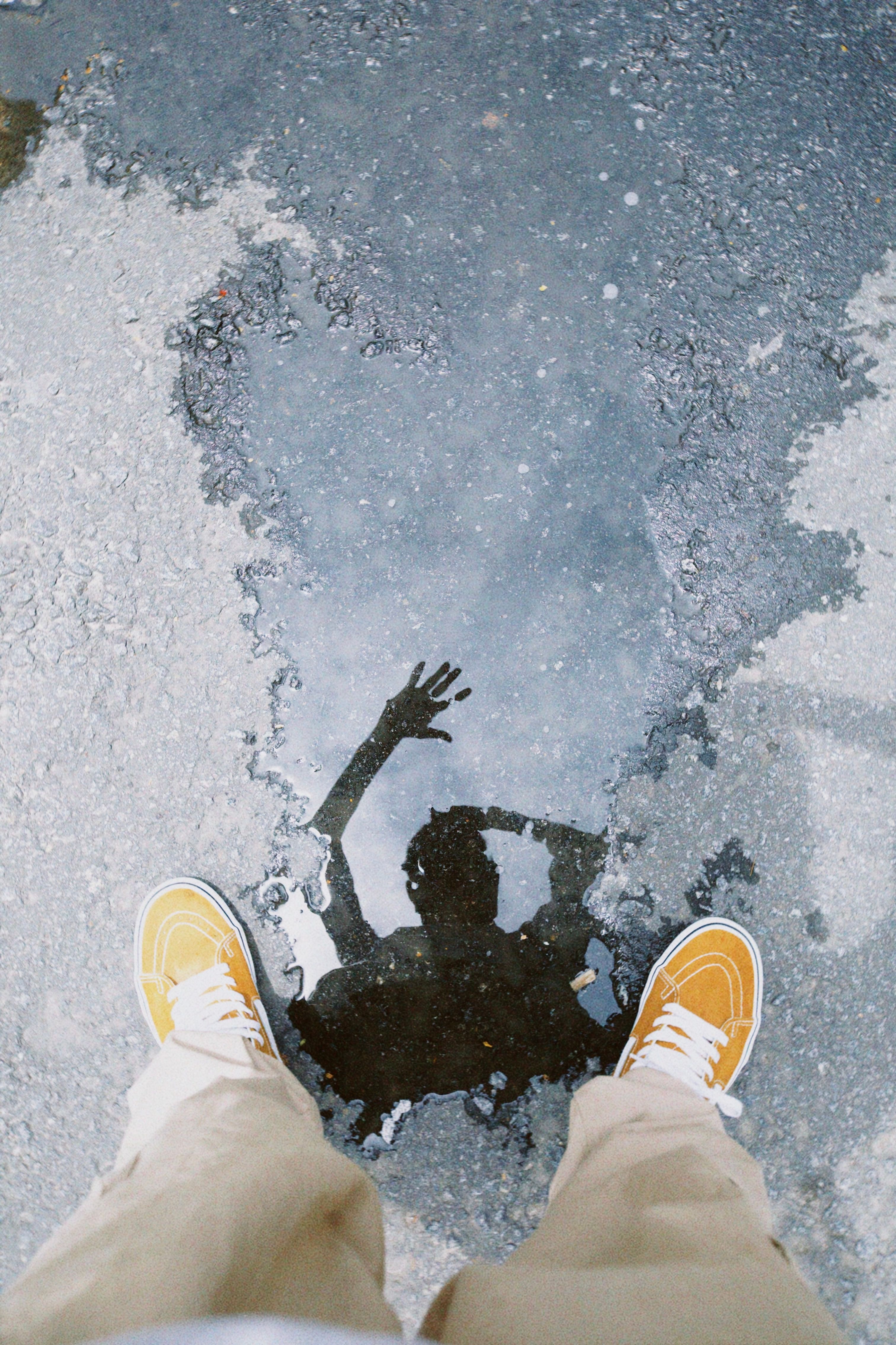 A person standing in a puddle with their shadow · Free Stock Photo