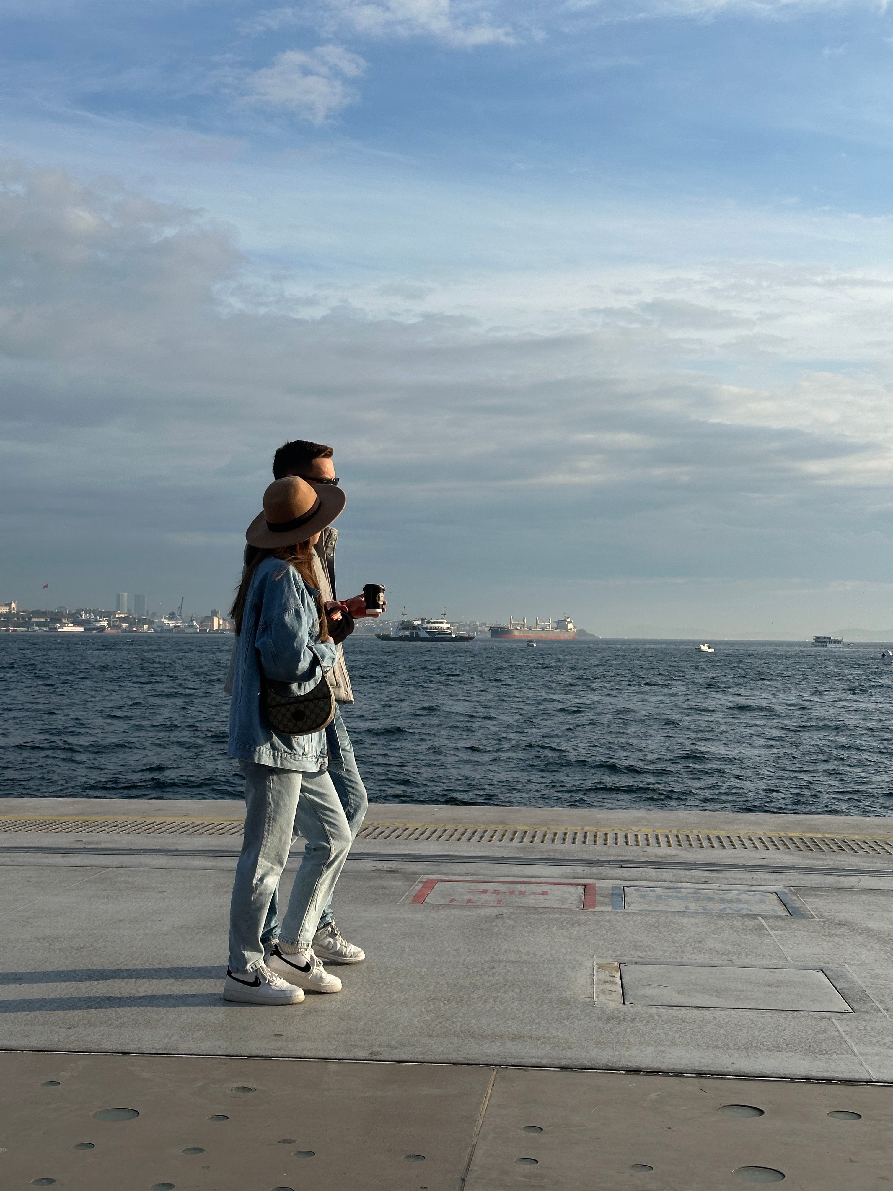 Couple Walking on Promenade on Sea Shore · Free Stock Photo