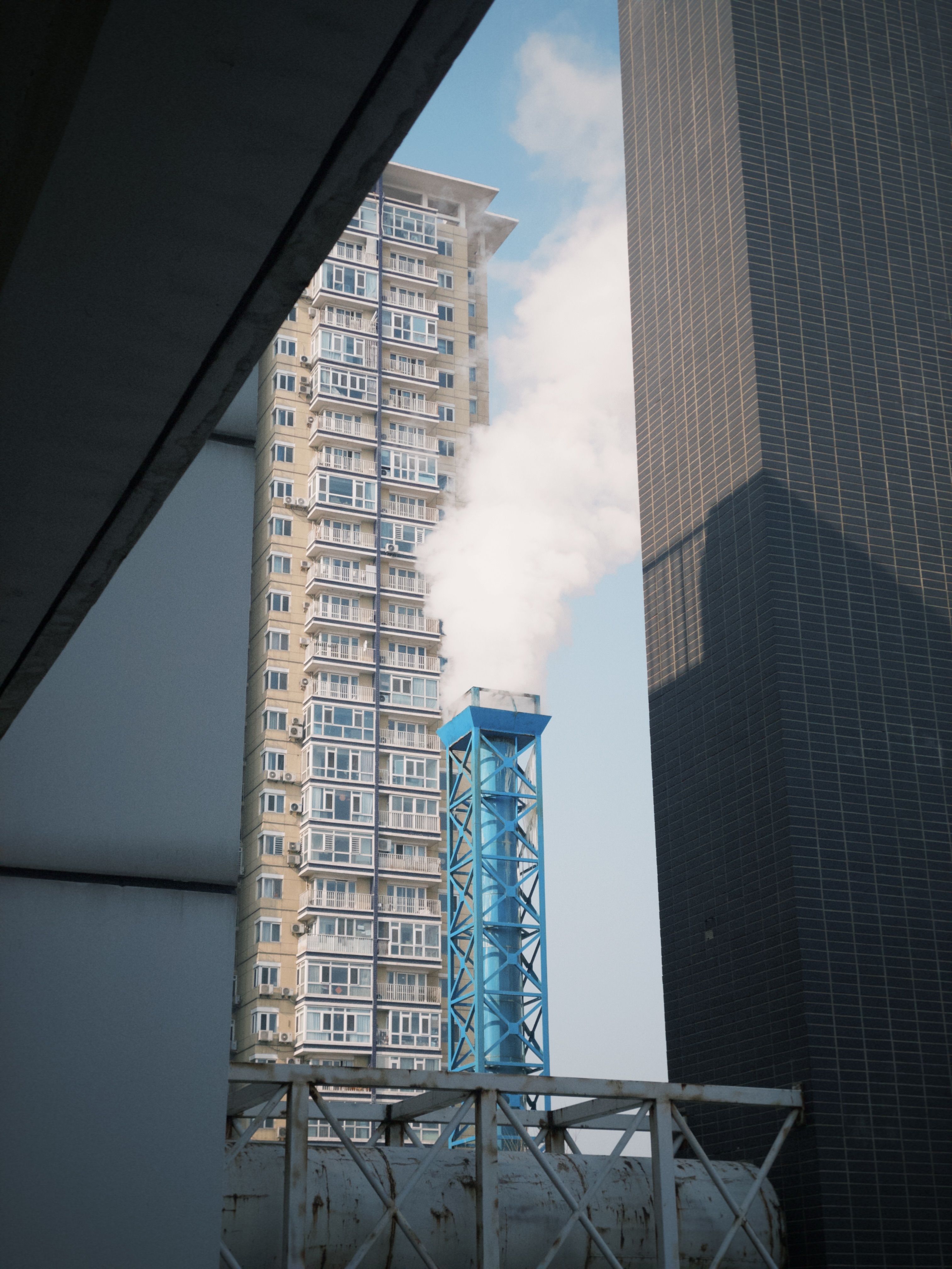 Chimney Smoke over Residential Skyscraper · Free Stock Photo