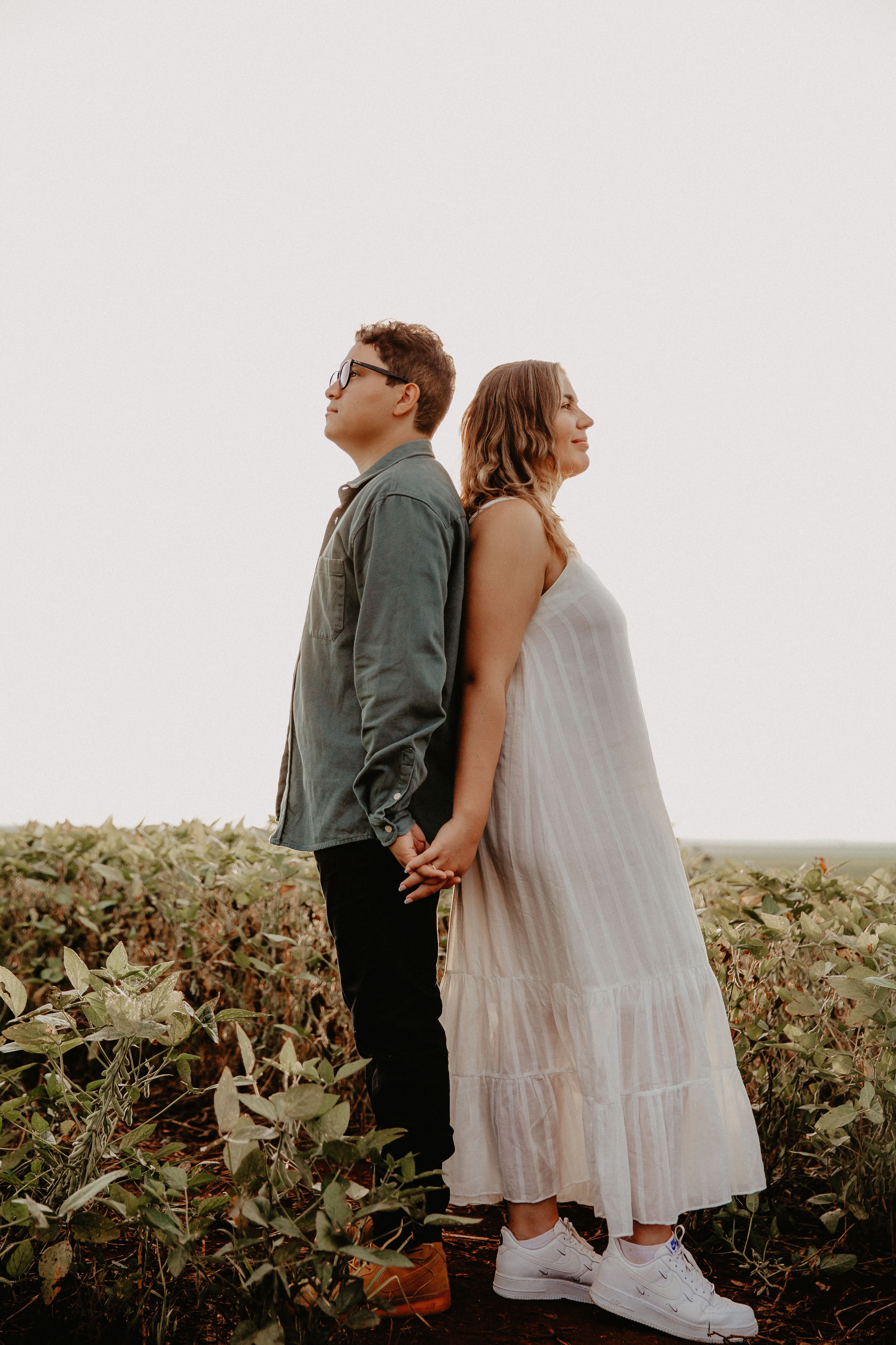 Couple Standing Back to Back and Holding Hands · Free Stock Photo
