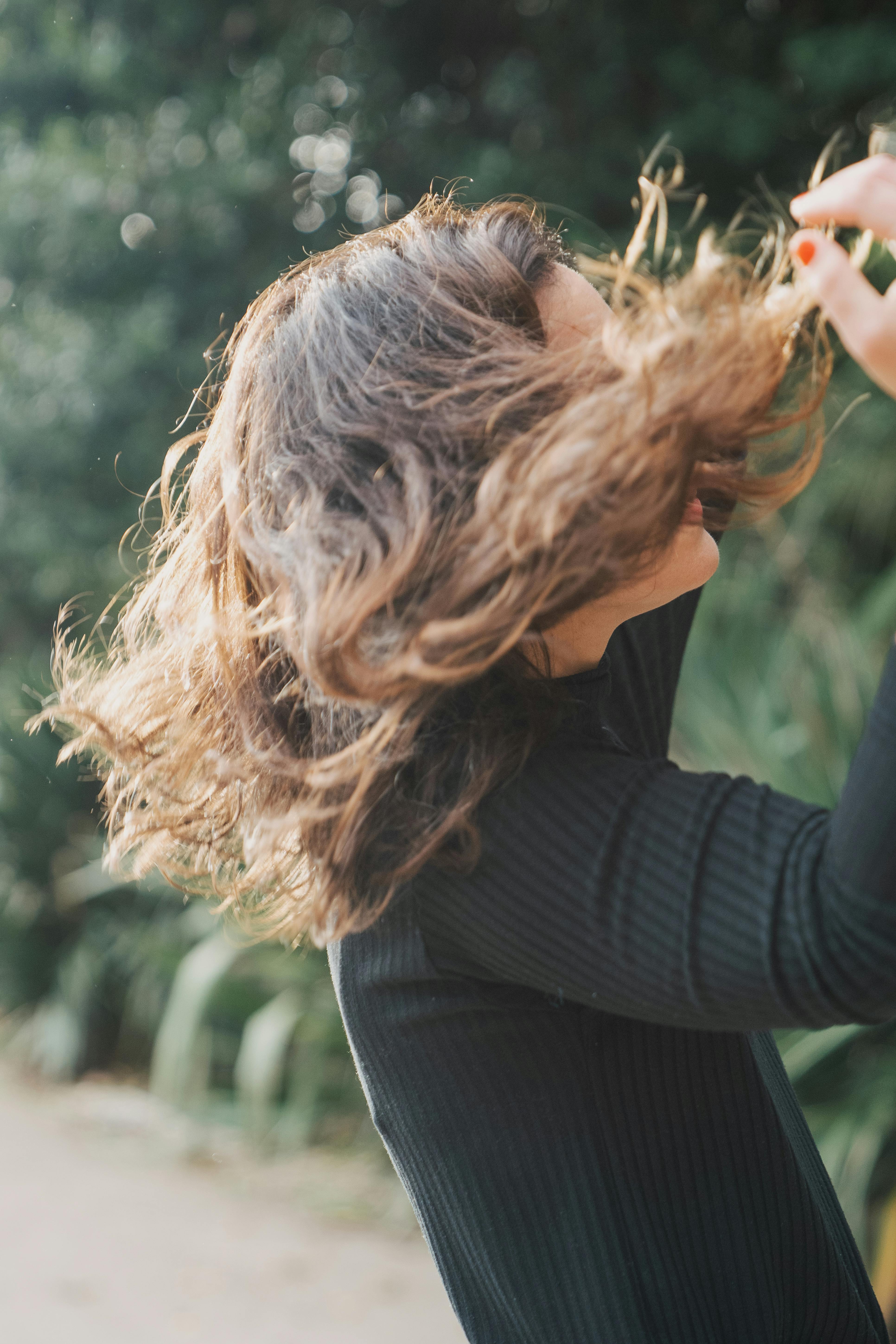 Woman in Black is Tousling Hair · Free Stock Photo