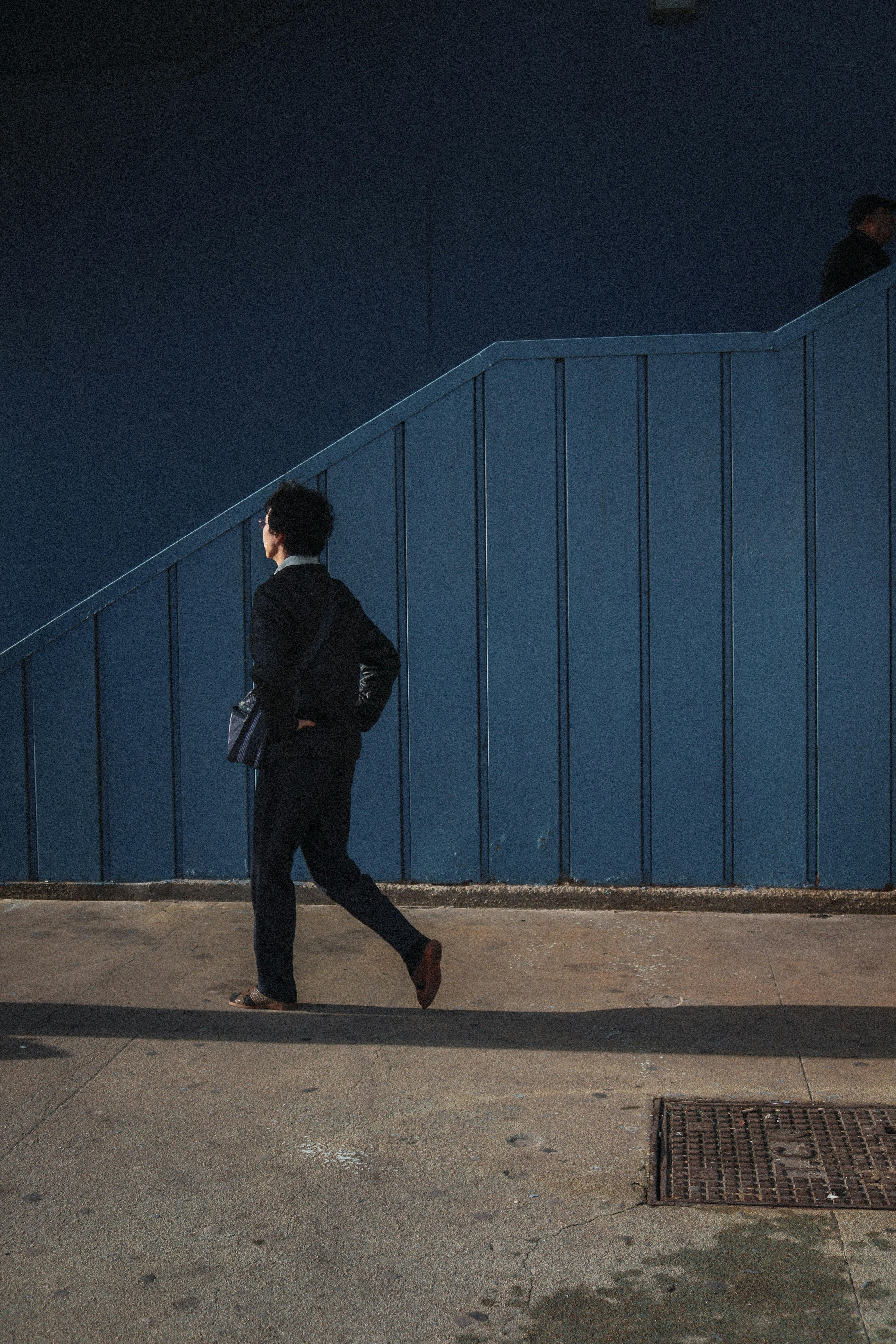 Man Walking near Blue Wall · Free Stock Photo