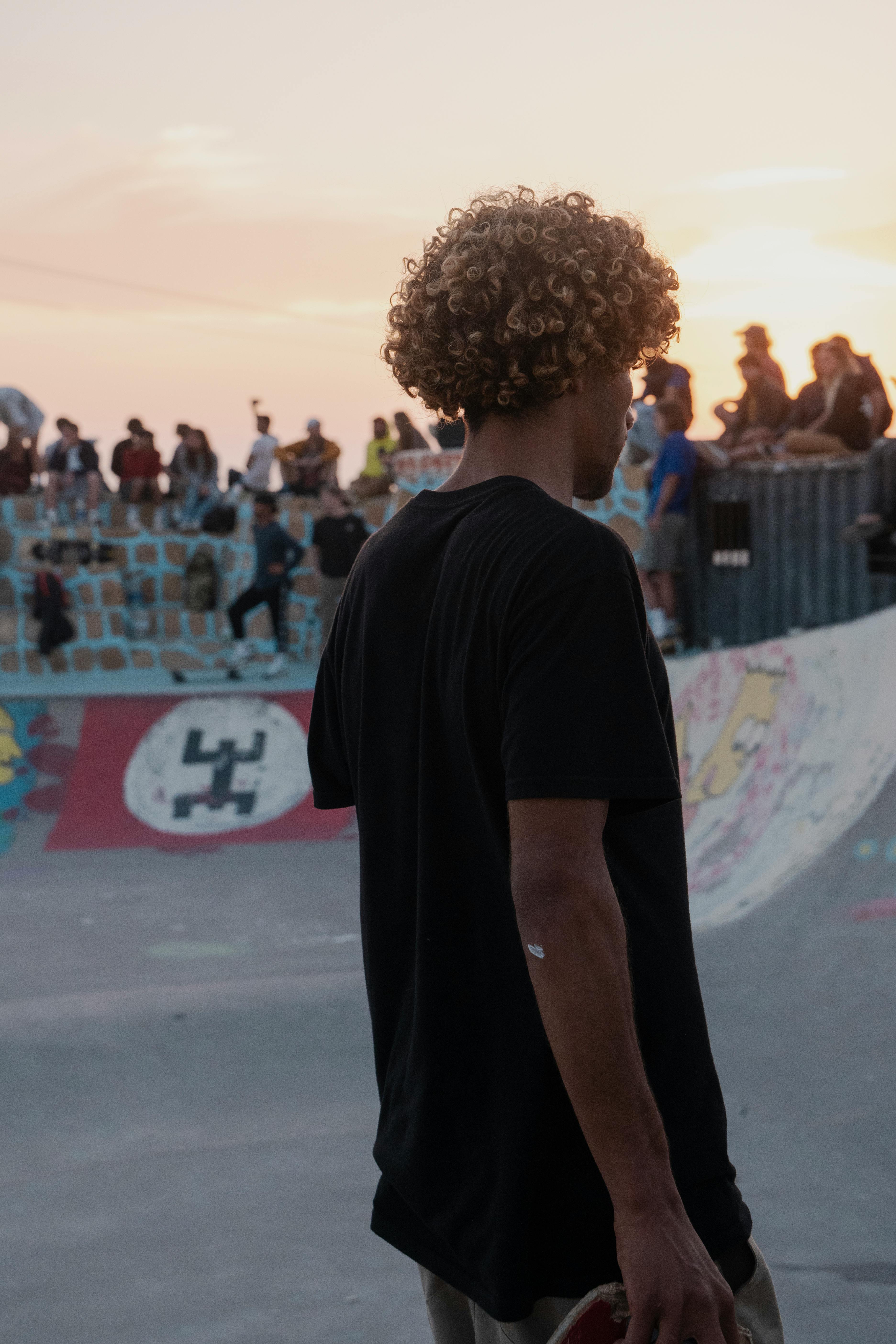 Skateboarder with Curly Hair in the Skatepark Ramp · Free Stock Photo