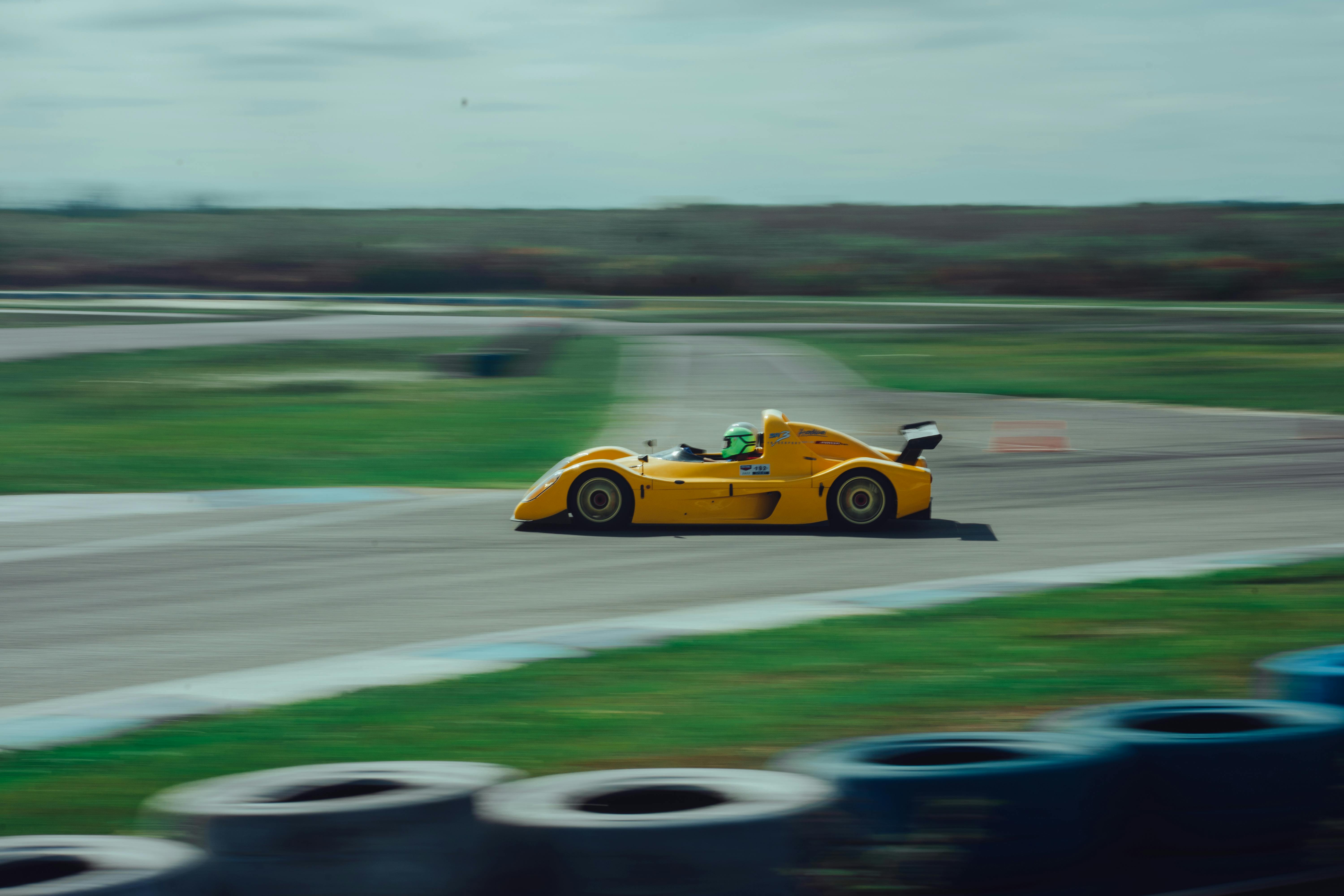 A yellow race car on a track · Free Stock Photo