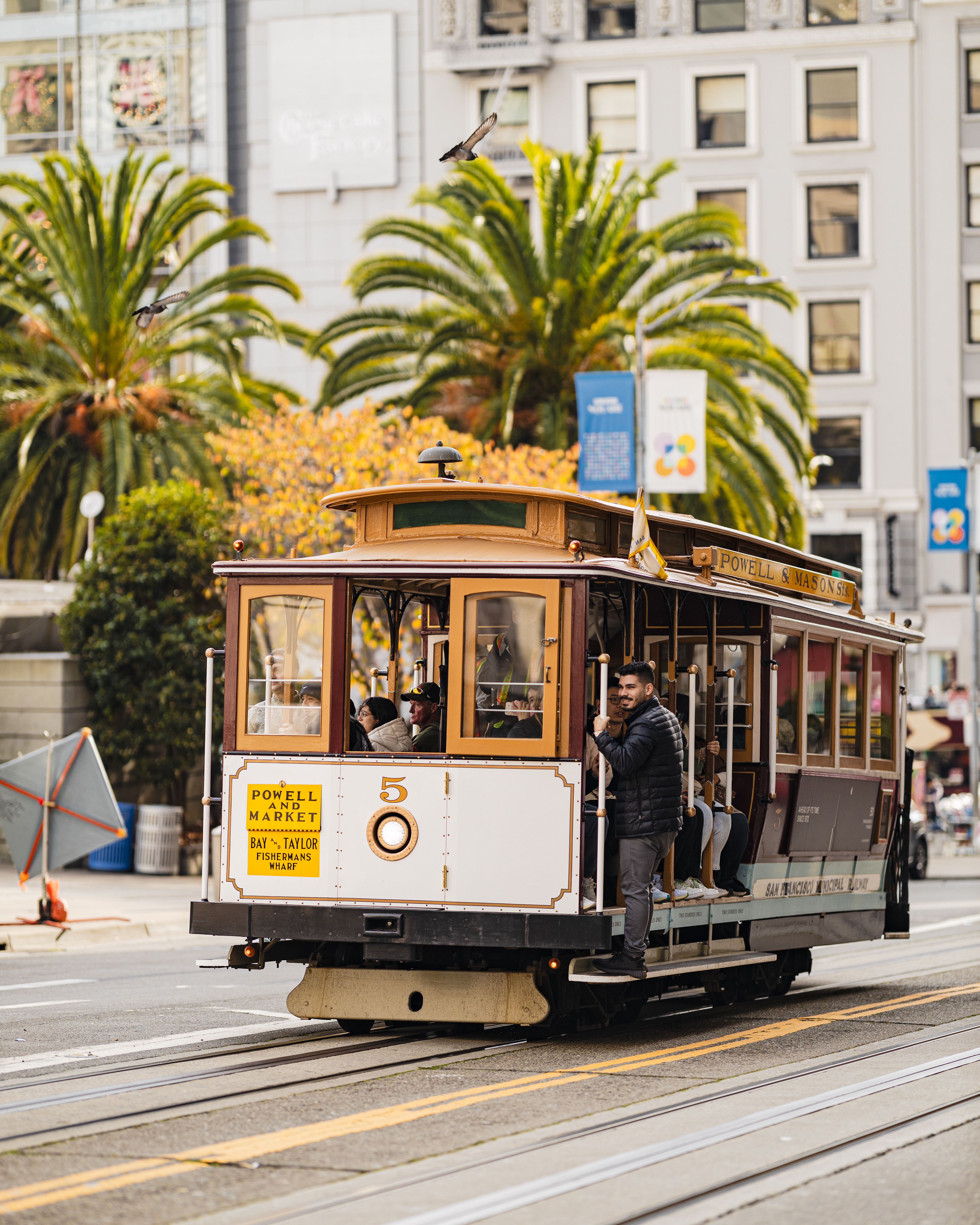 A trolley car is traveling down a street · Free Stock Photo