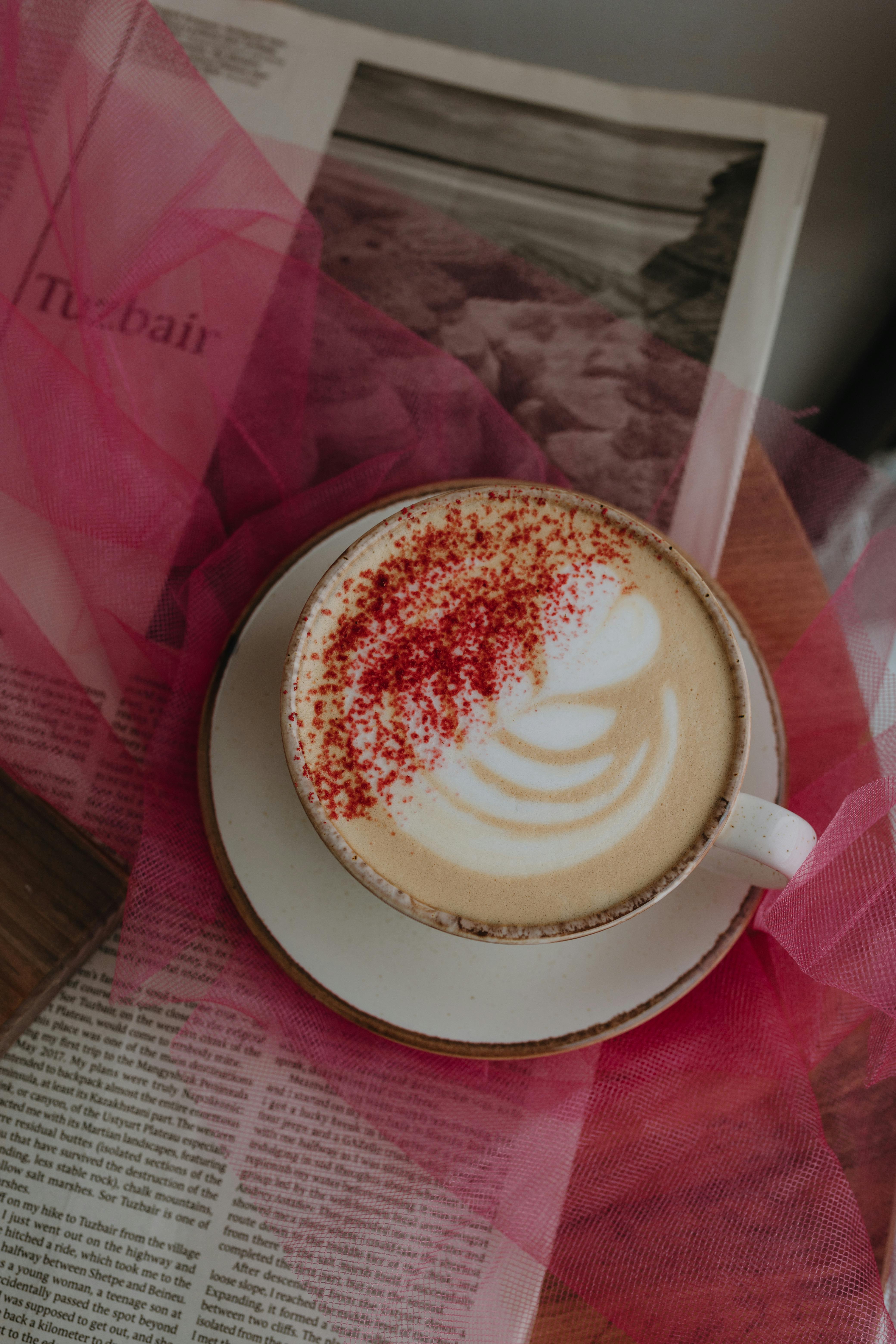 A cup of coffee with sprinkles on top of a newspaper · Free Stock Photo