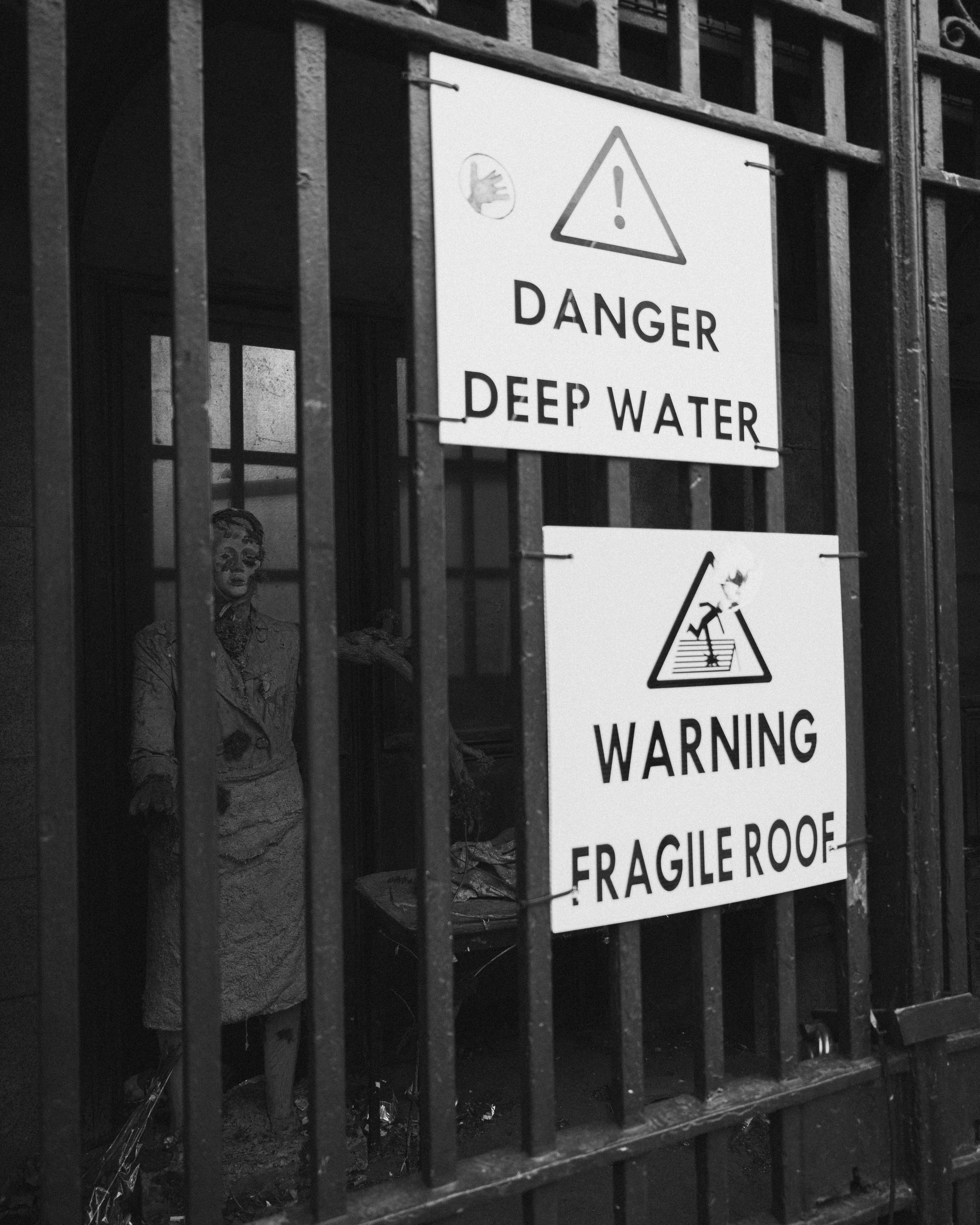 Warnings on Metal Bars by Creepy Figure · Free Stock Photo