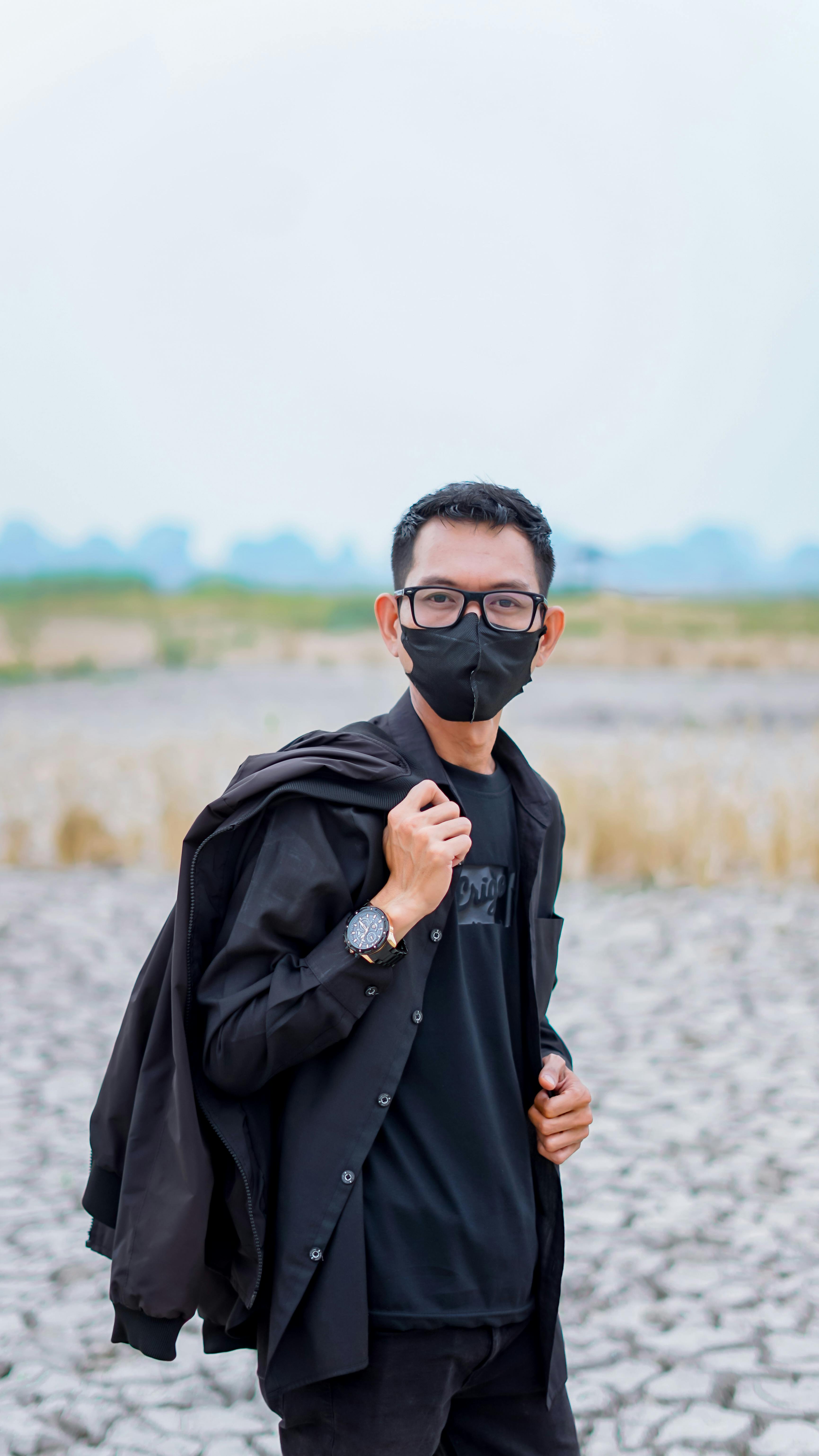 Man in a Face Mask Posing in a Parched Land · Free Stock Photo