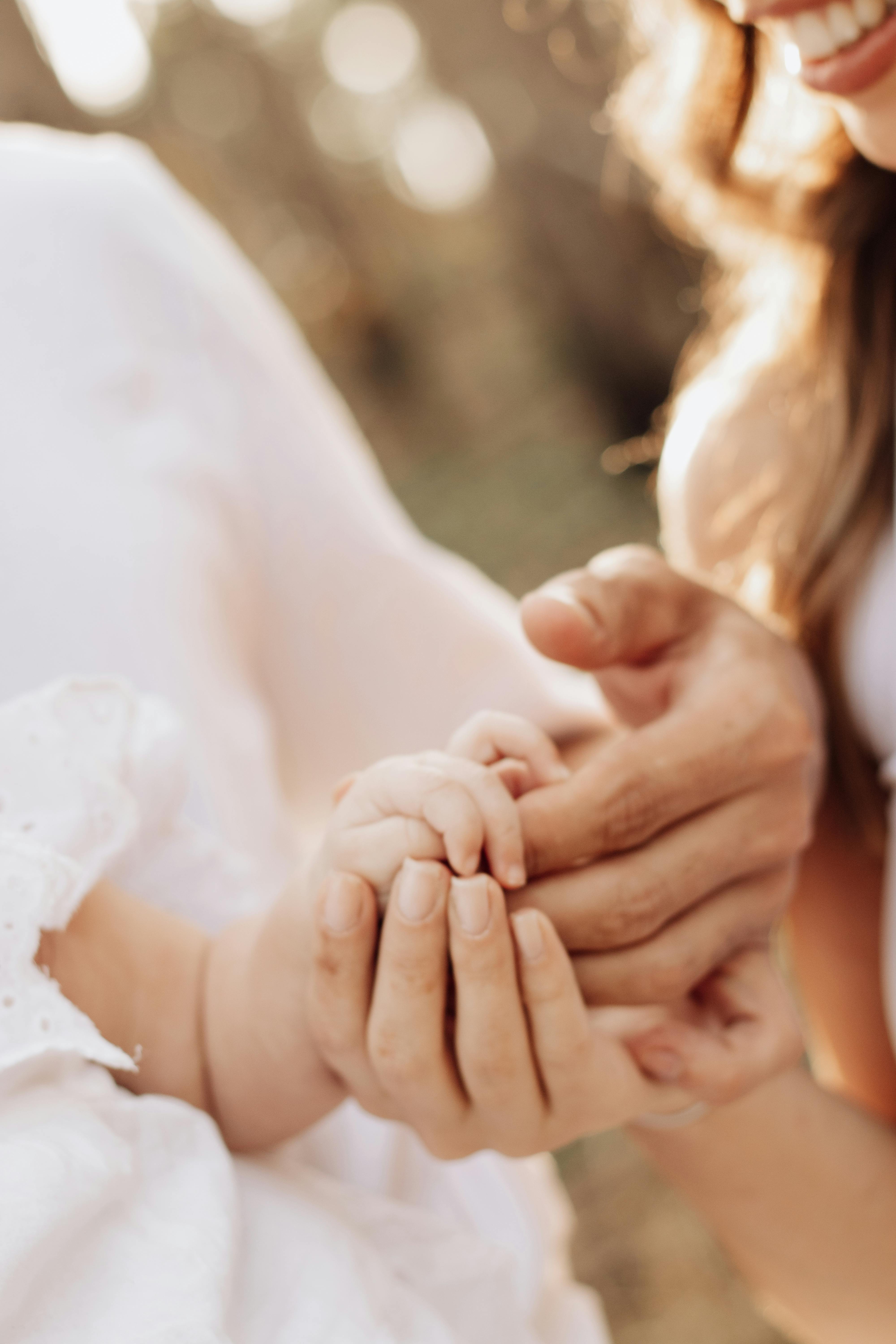 Hands of Parents Touching Hand of Baby · Free Stock Photo