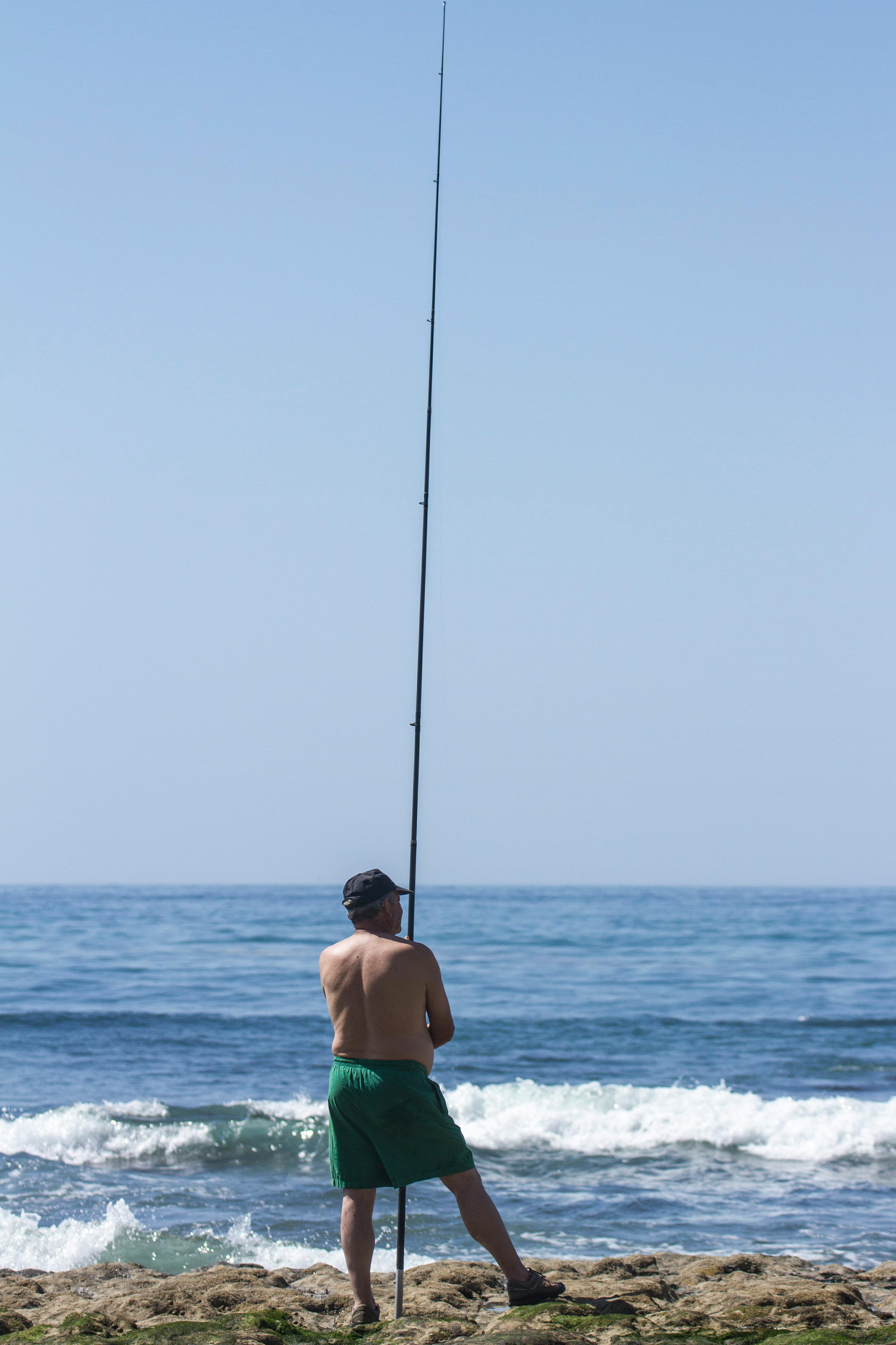 Man Fishing on Sea Shore · Free Stock Photo