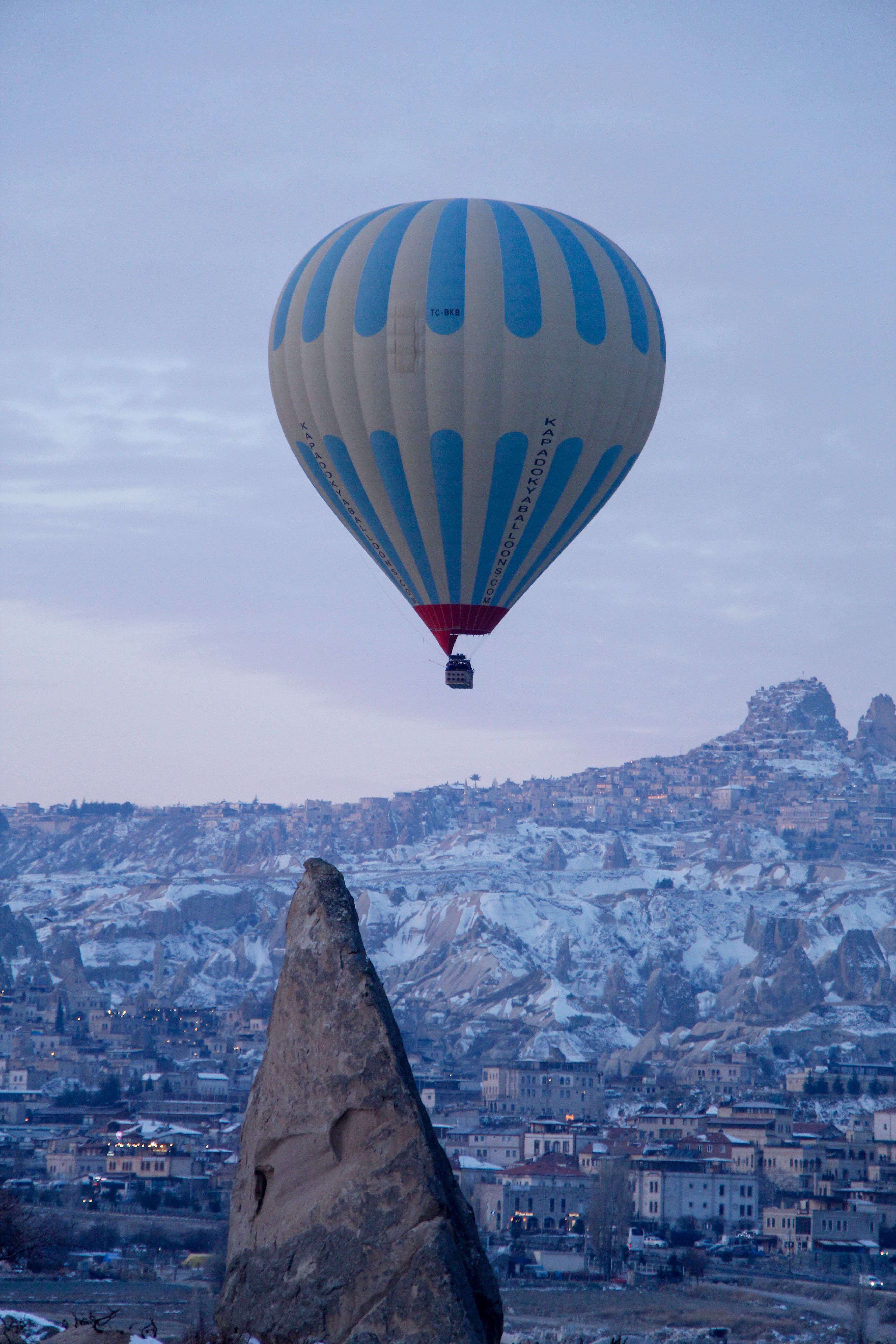 A hot air balloon flying over a rock formation · Free Stock Photo