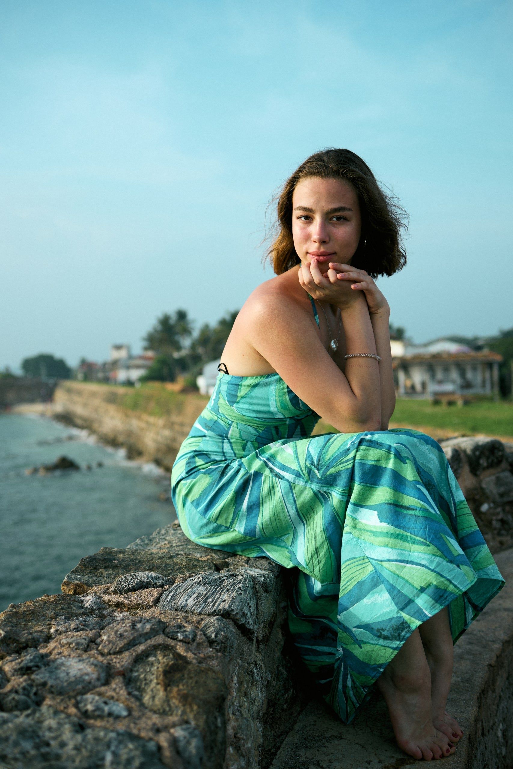 Woman Wearing Turquoise Dress on a Rocky Beach · Free Stock Photo