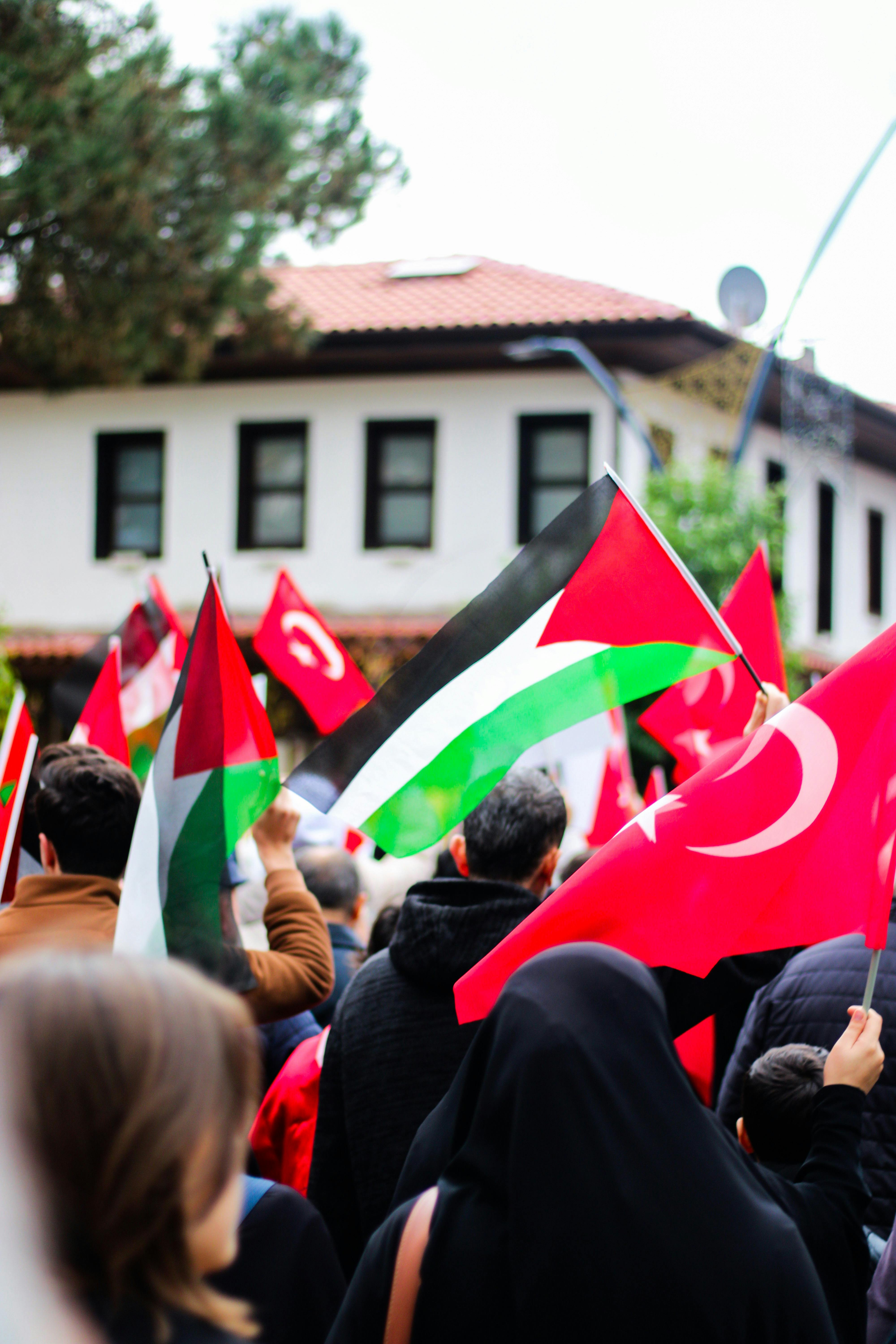 A group of people holding flags and walking · Free Stock Photo