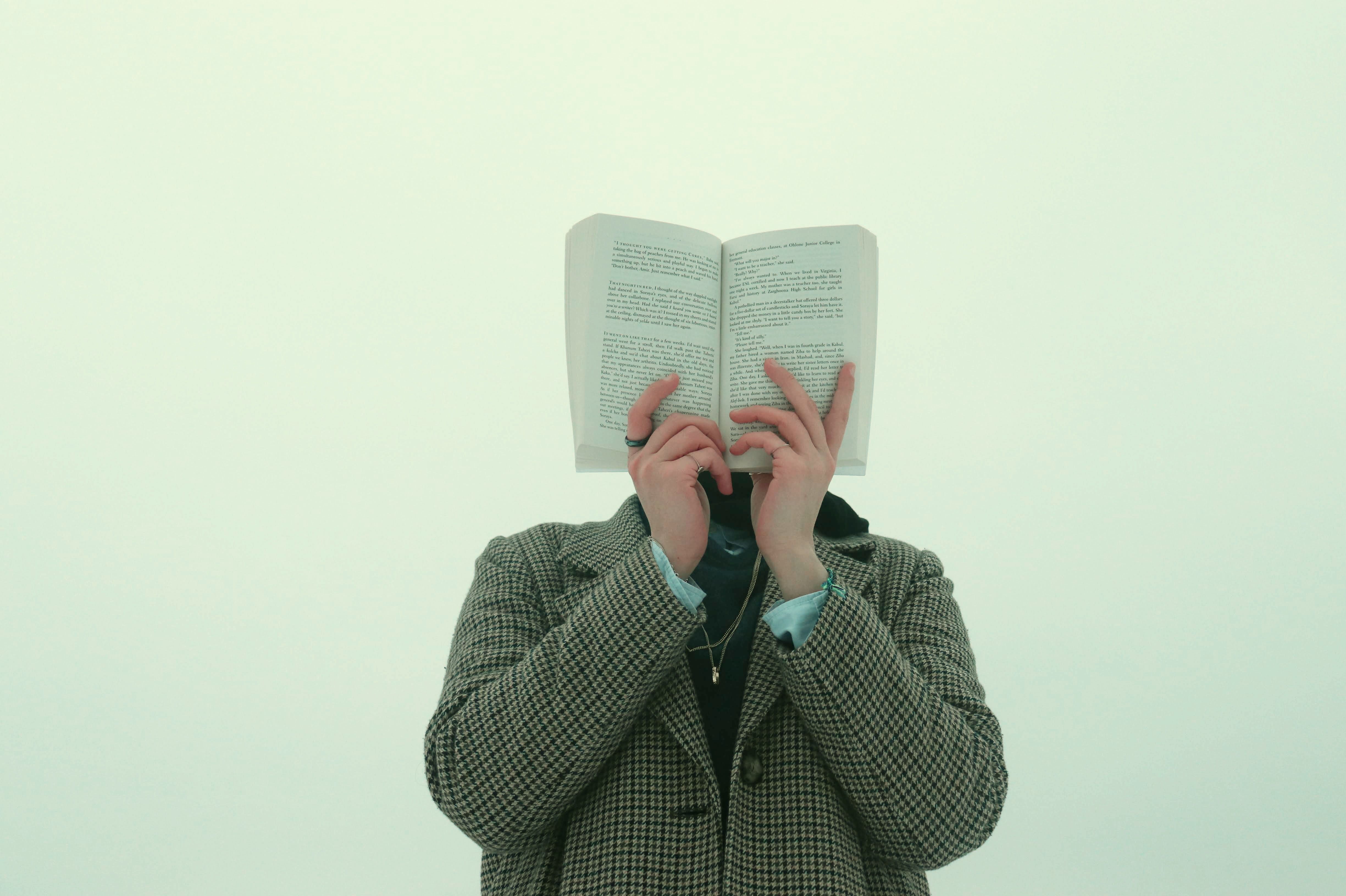Person in Suit Holding Book over Head · Free Stock Photo