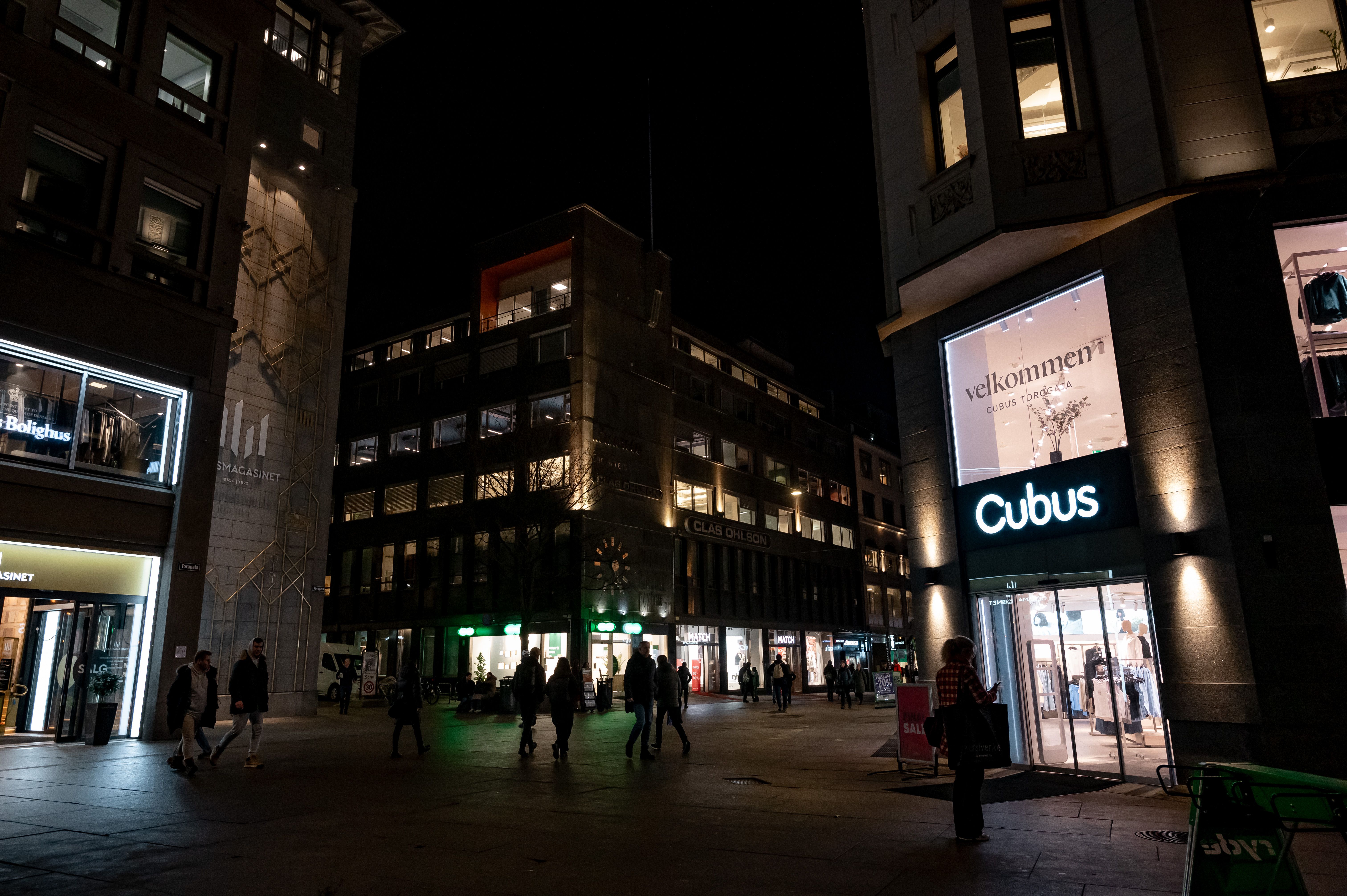 A city street at night with people walking around · Free Stock Photo