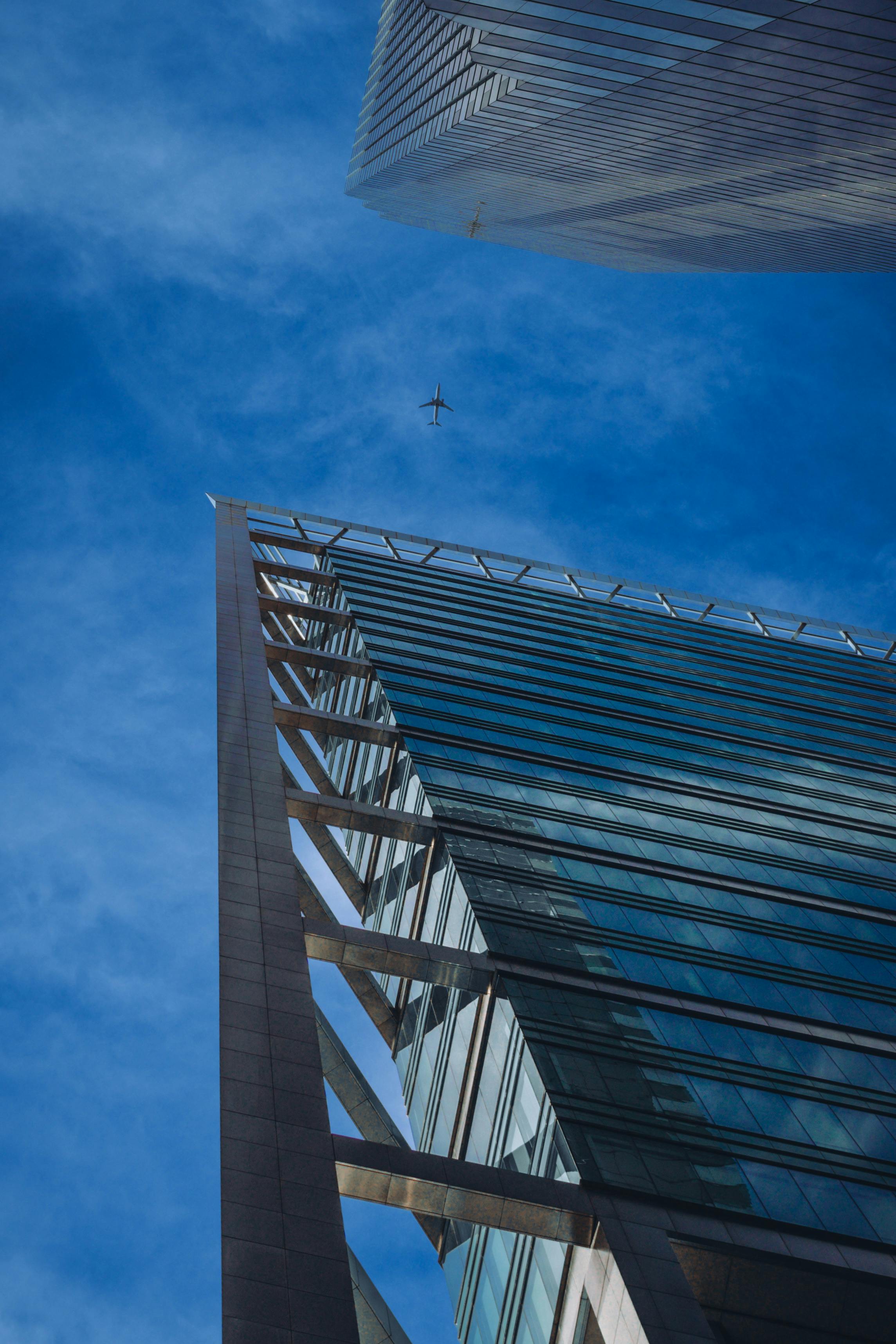 airplane flying over buildings · Free Stock Photo