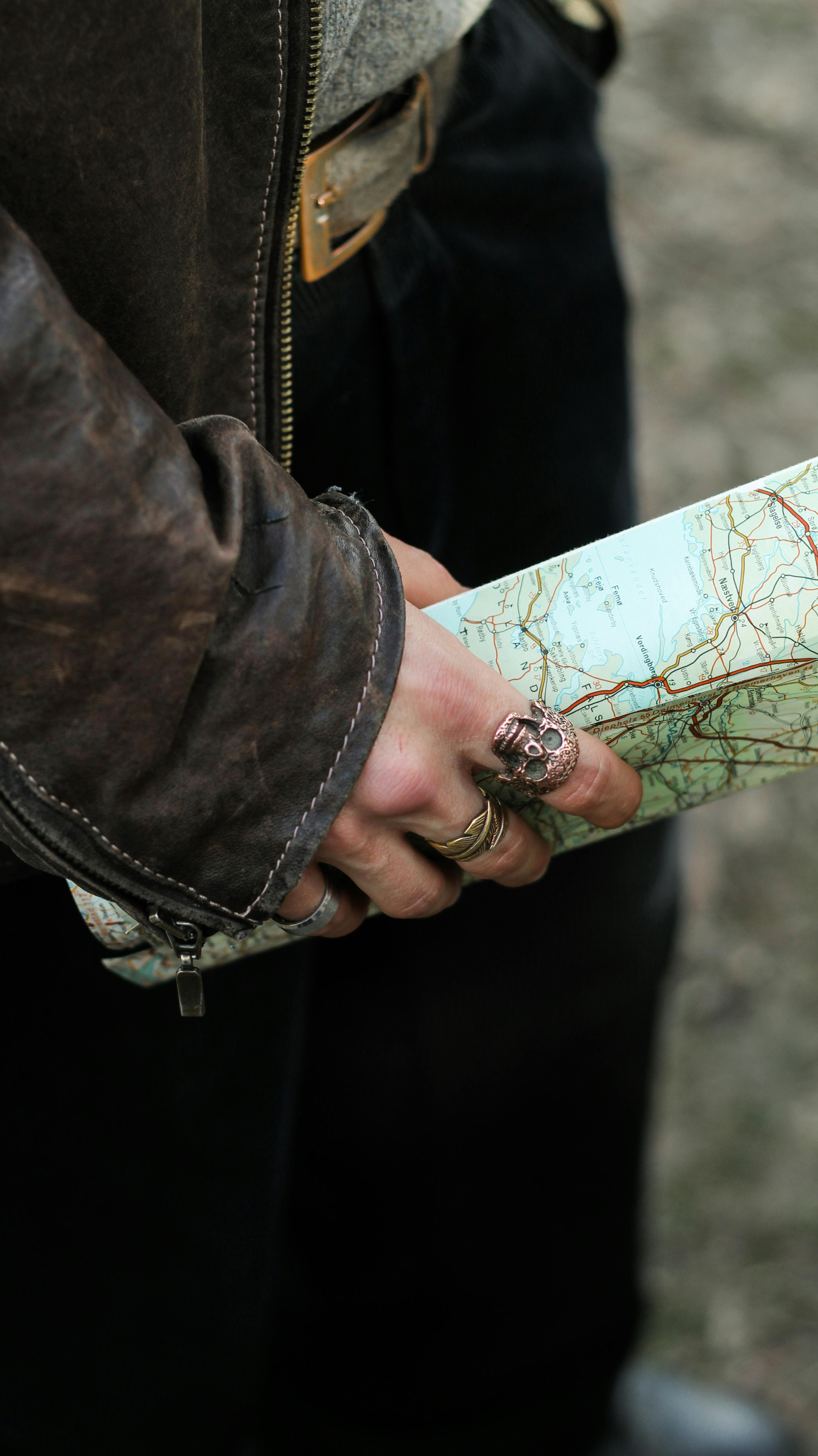 A person holding a map in their hand · Free Stock Photo