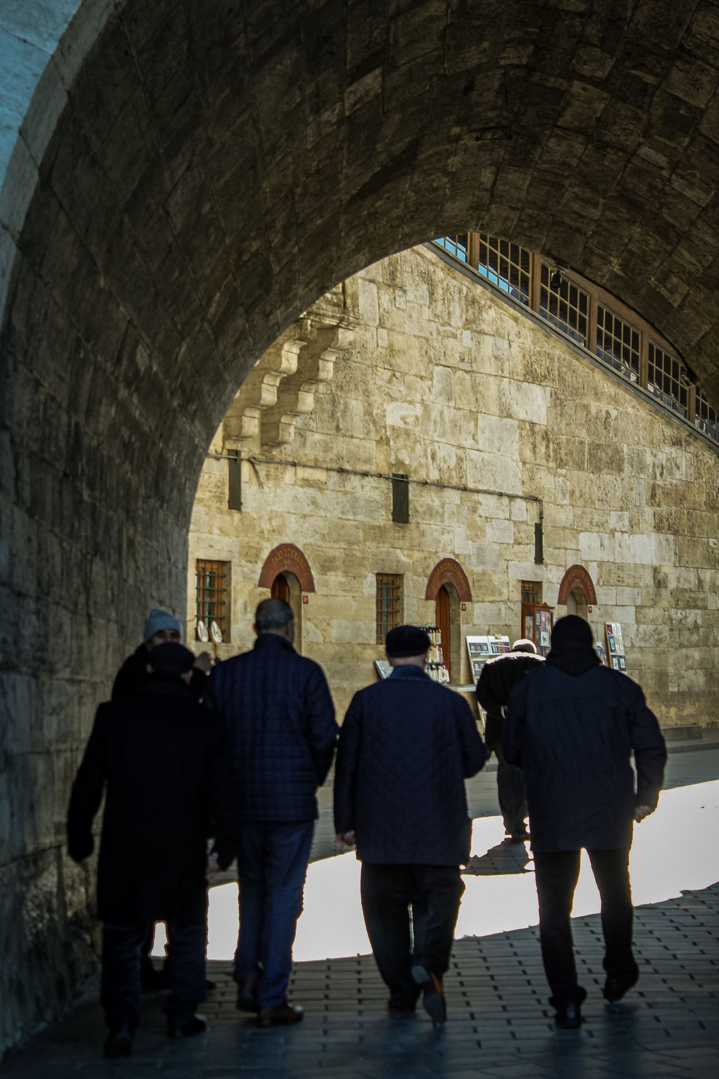 Back View of People Walking under an Arch · Free Stock Photo