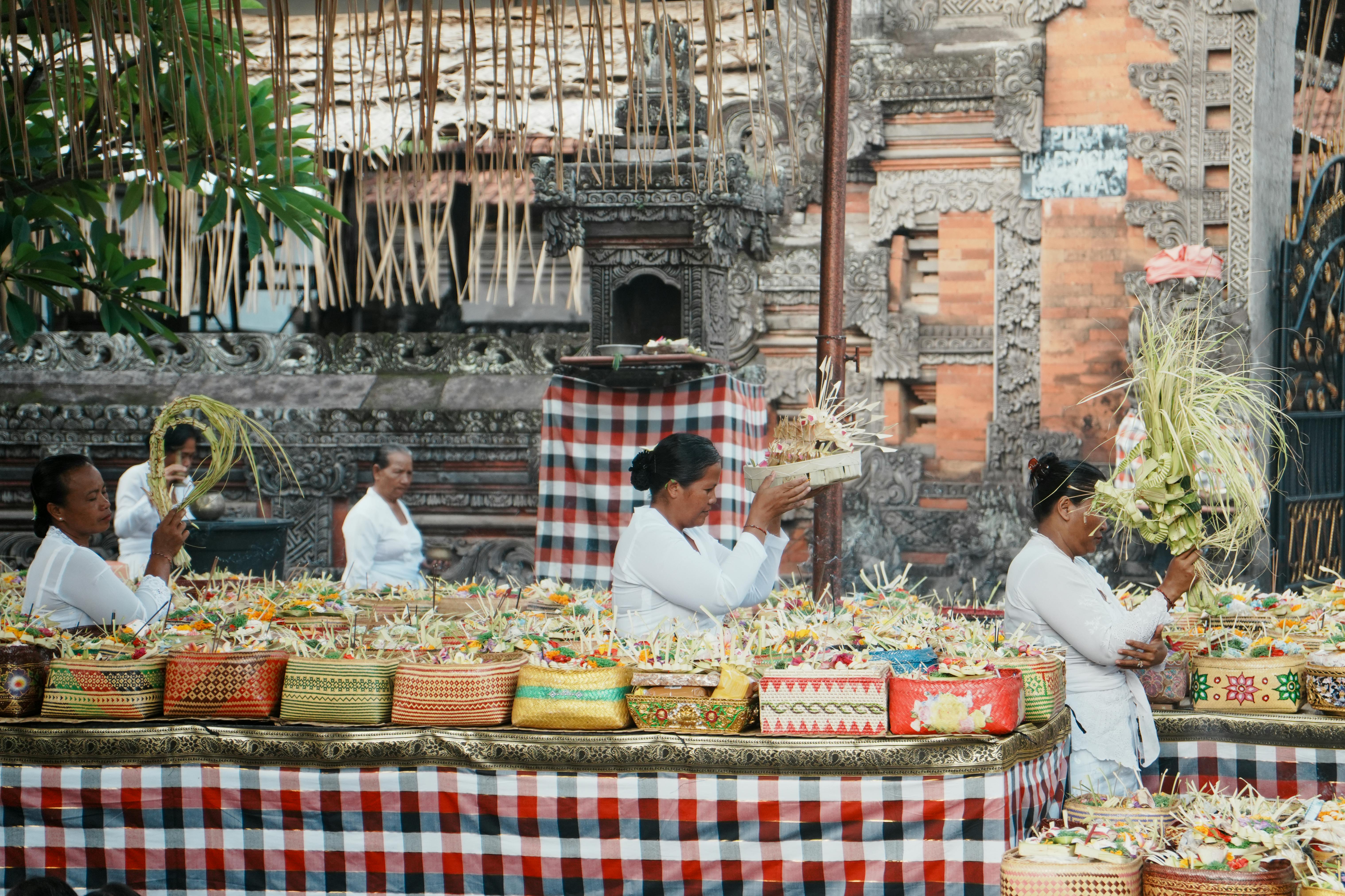 Women Placing Baskets with Food on a Temple Table · Free Stock Photo