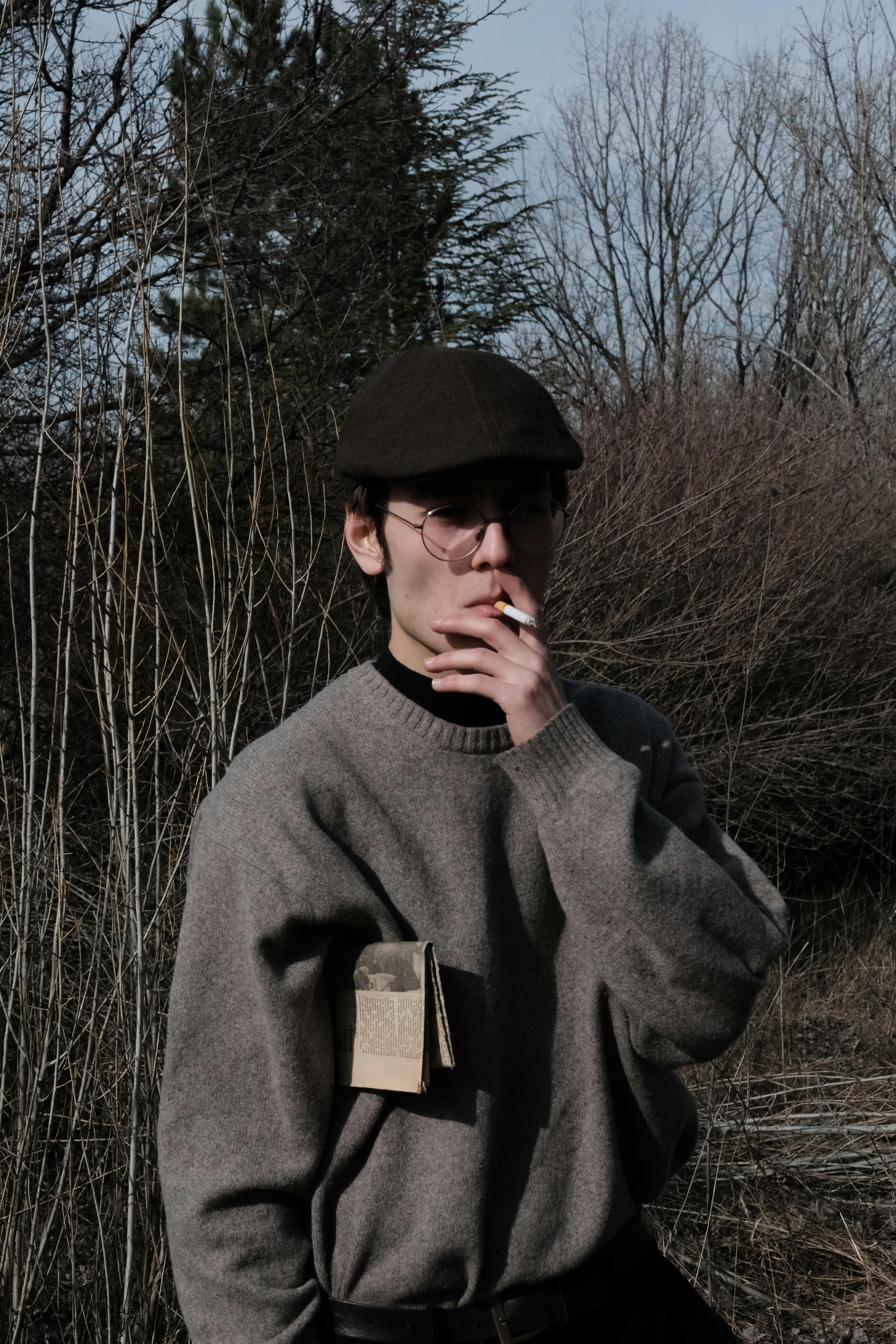 Young Man with a Yellowed Newspaper Under His Arm Smoking a Cigarette ...