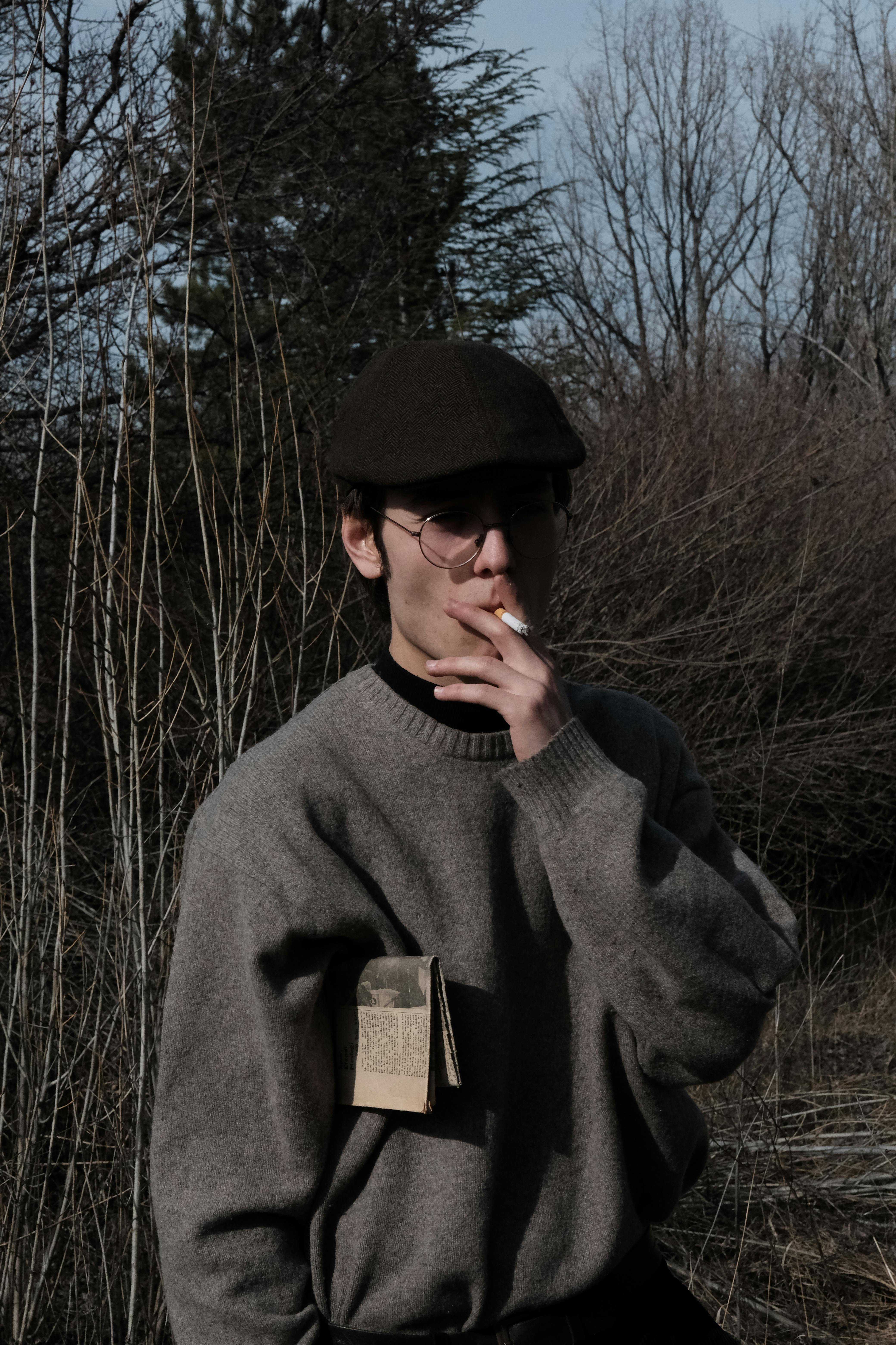 Young Man with a Old Newspaper Under His Arm Smoking a Cigarette · Free ...