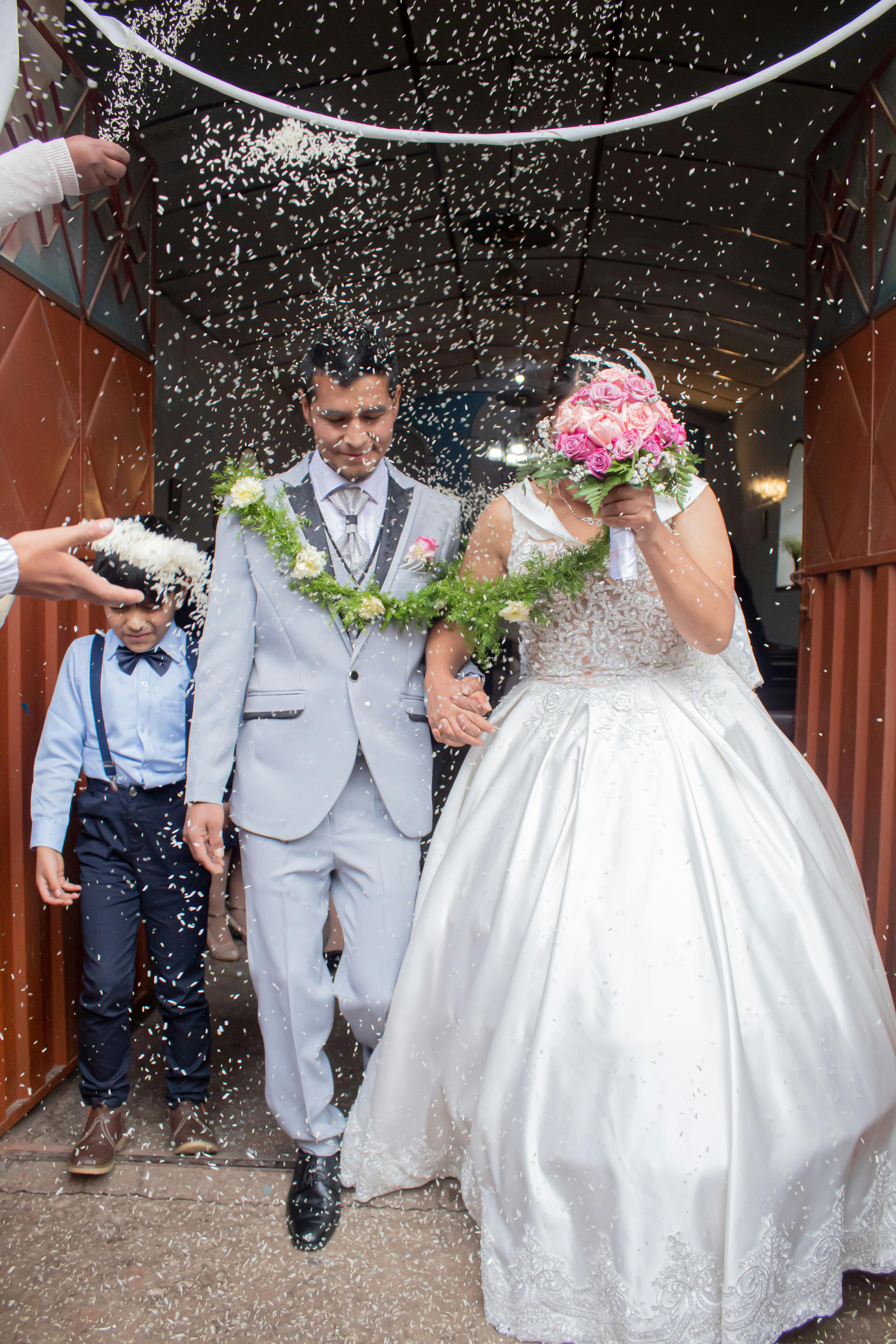 Guests Pouring Rice on Newlyweds · Free Stock Photo