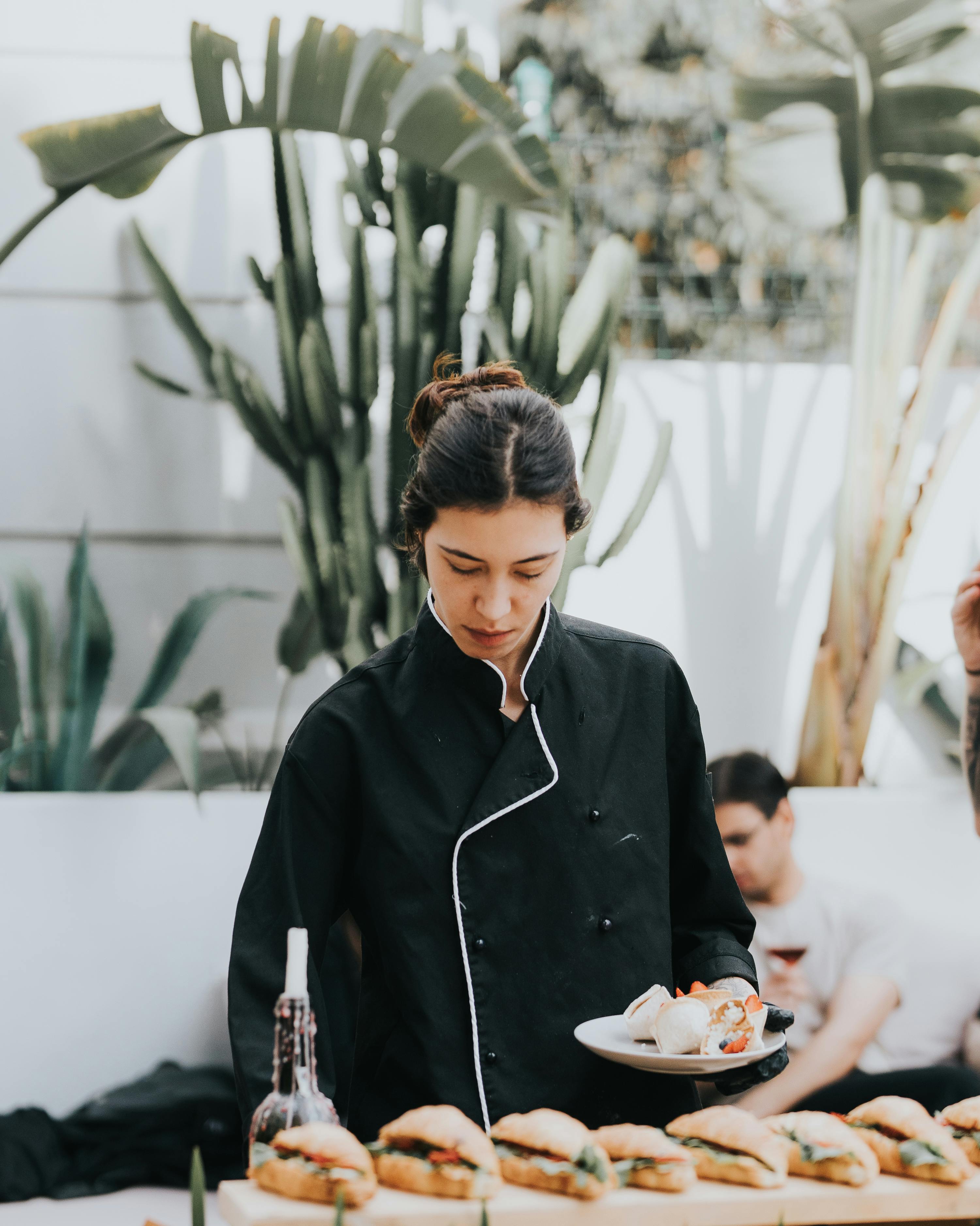 Woman Standing by Table with Croissant Sandwiches · Free Stock Photo