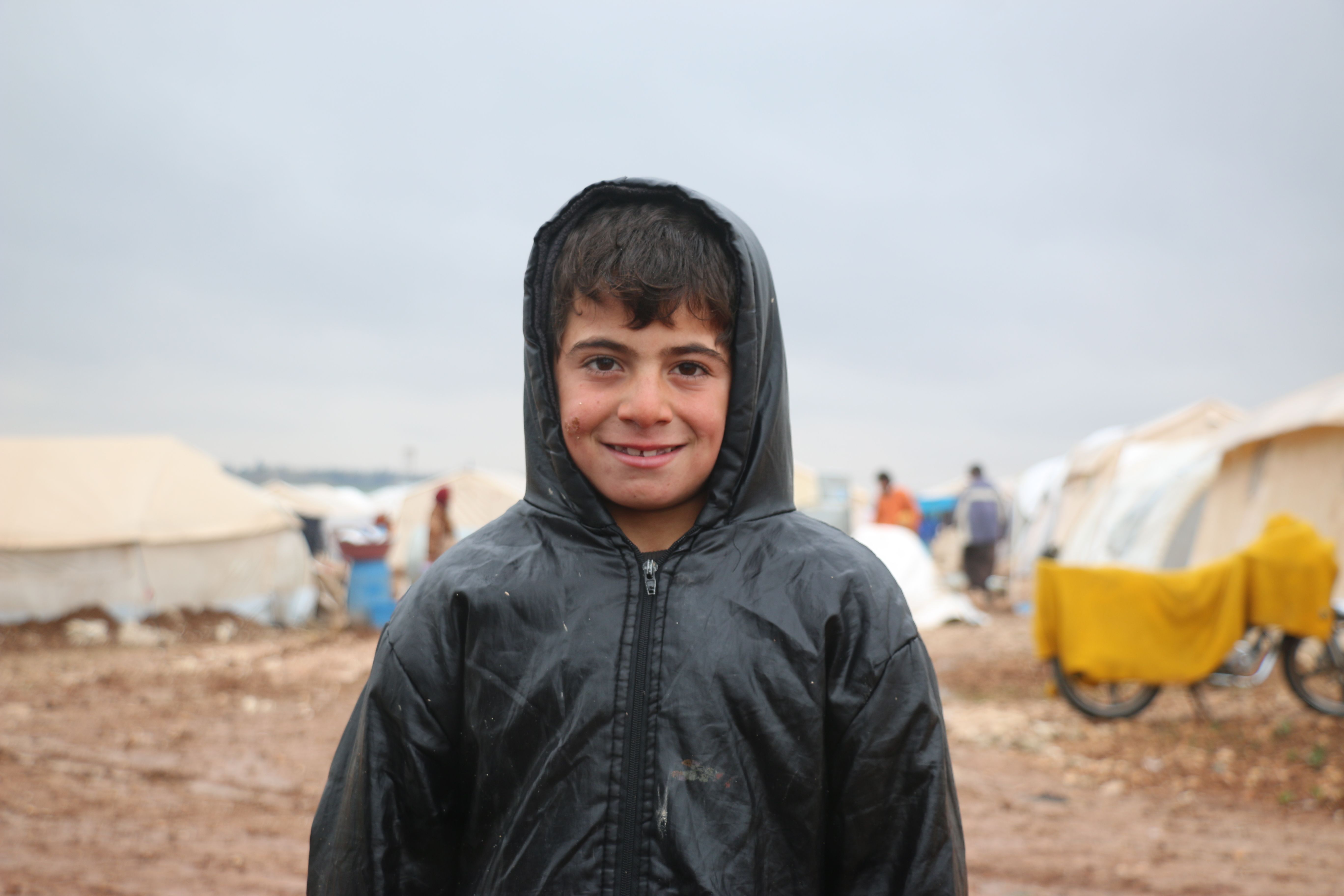 Boy in a Black Jacket in a Refugee Camp · Free Stock Photo