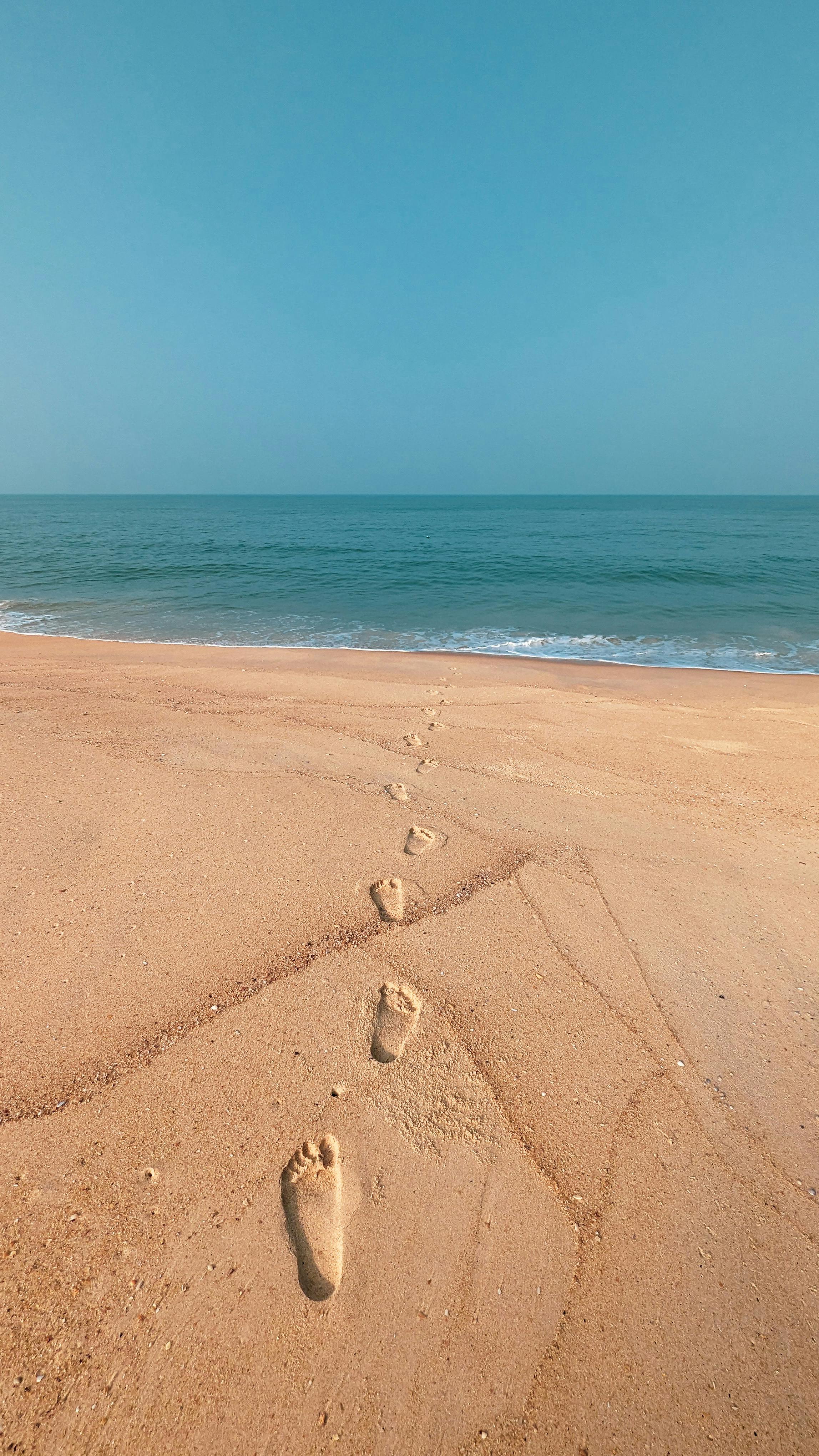 Footprints in the sand on a beach · Free Stock Photo