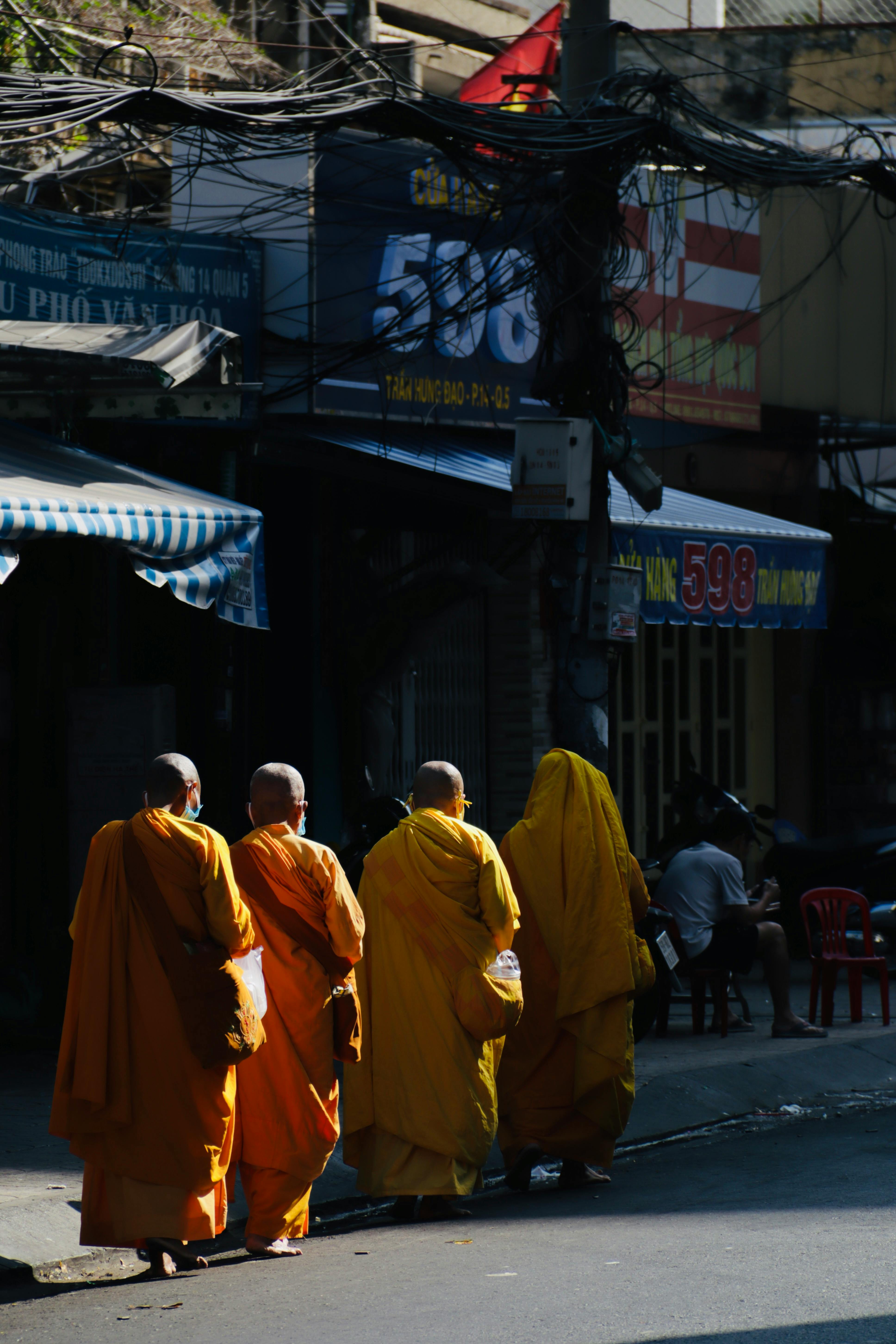 A group of monks walking down a street · Free Stock Photo