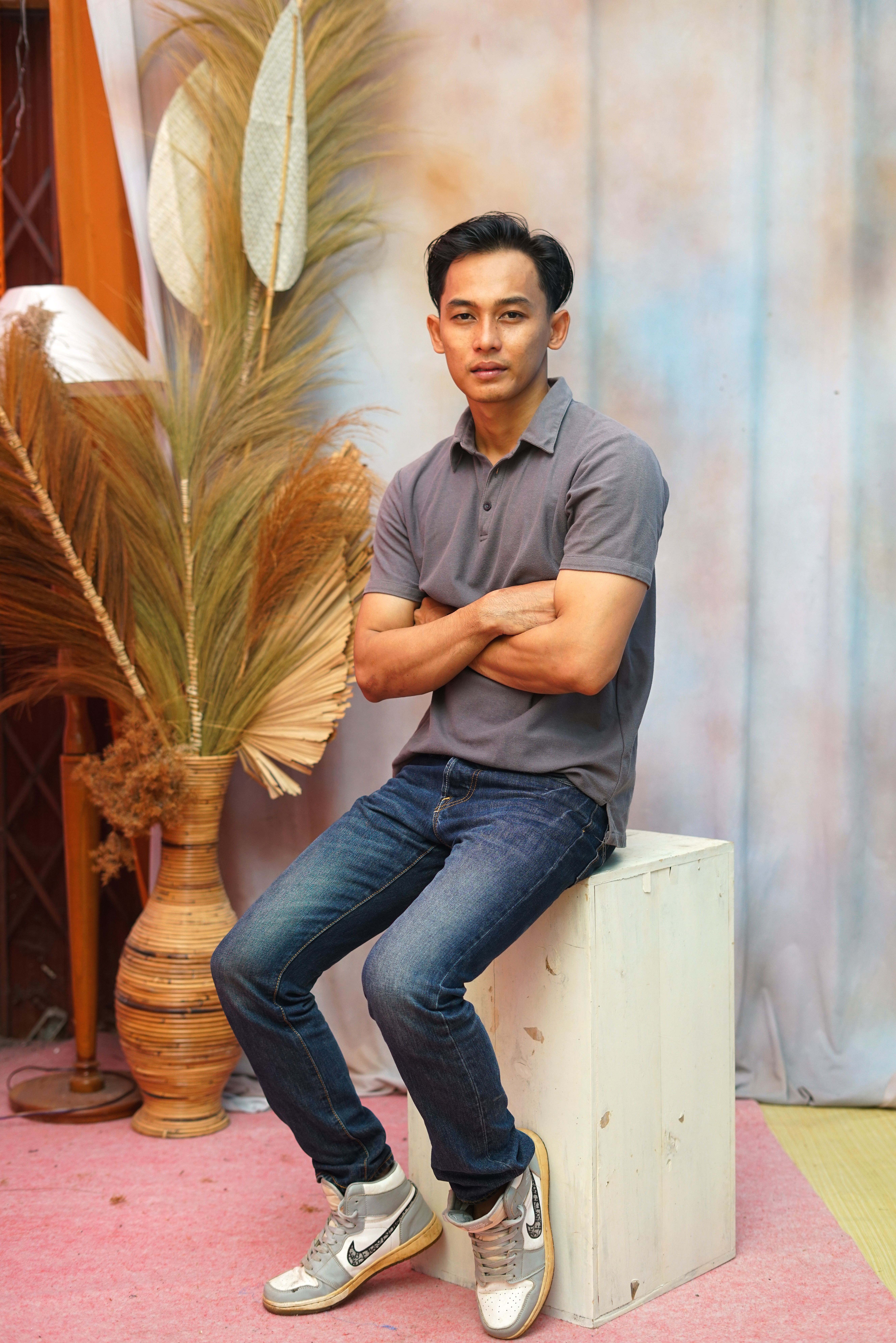A man sitting on a wooden box with a plant · Free Stock Photo
