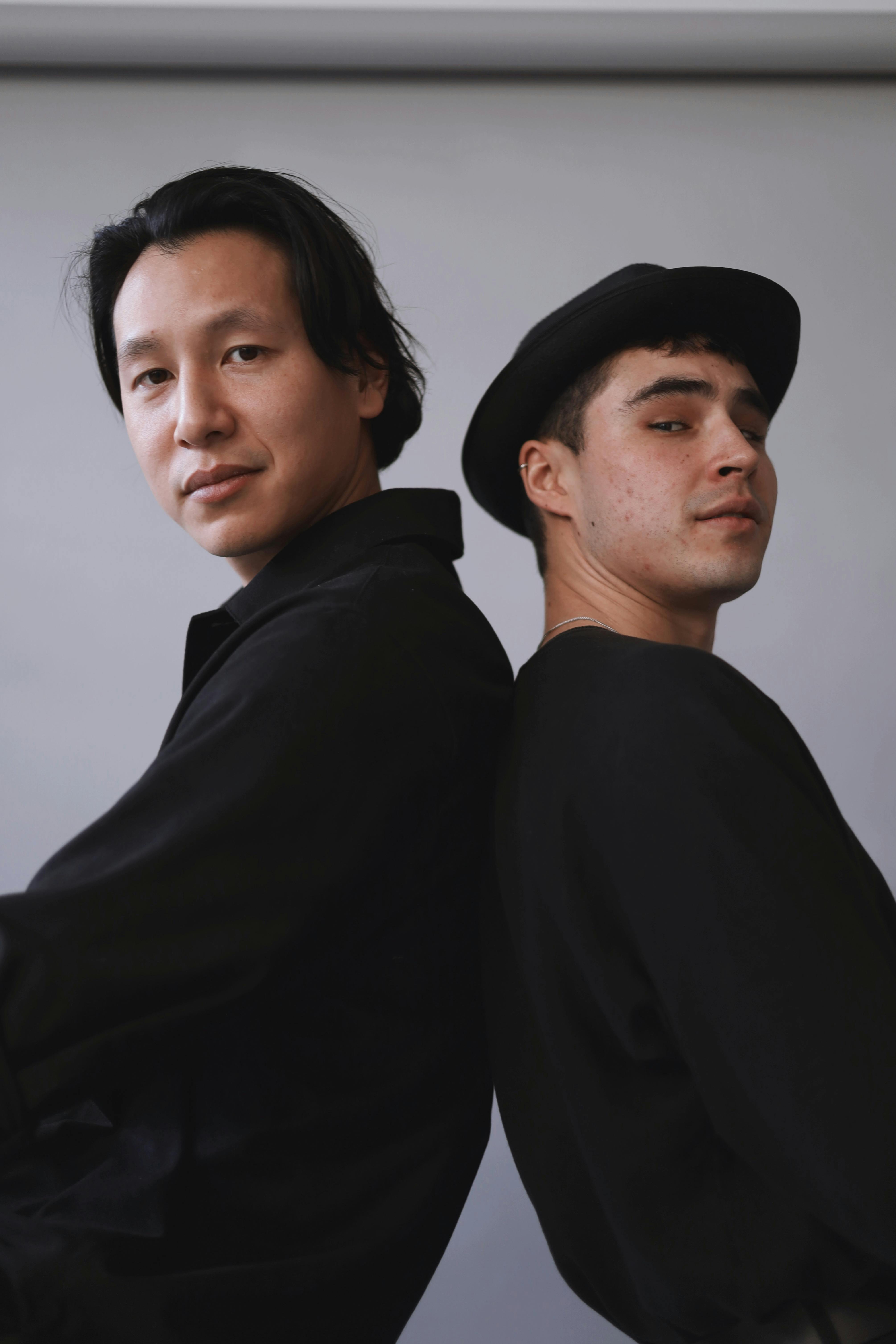 Two Men in Black Clothing Standing Back to Back · Free Stock Photo