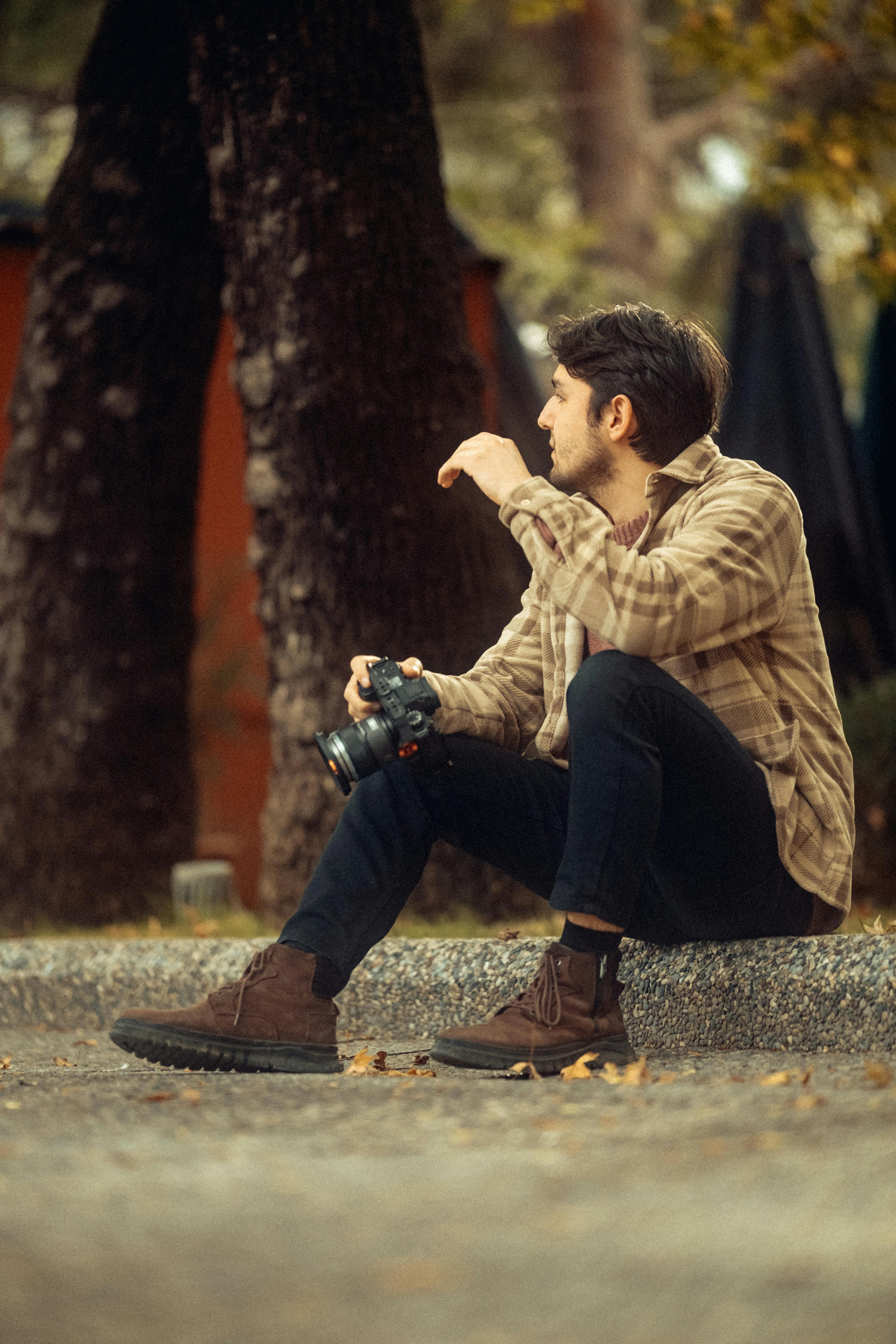 Man Sitting with Camera on Street · Free Stock Photo