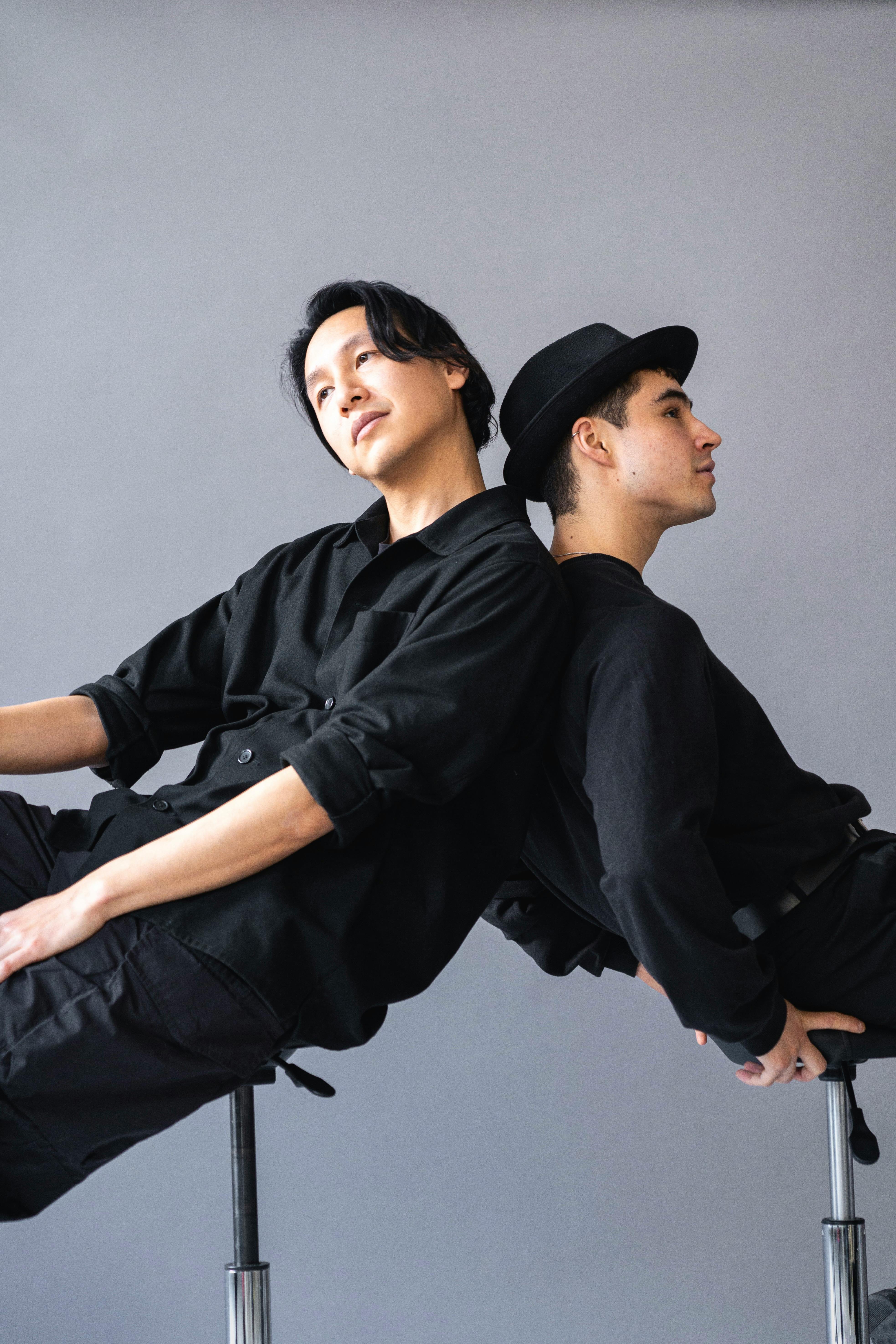 Men Leaning on Each Others Back · Free Stock Photo