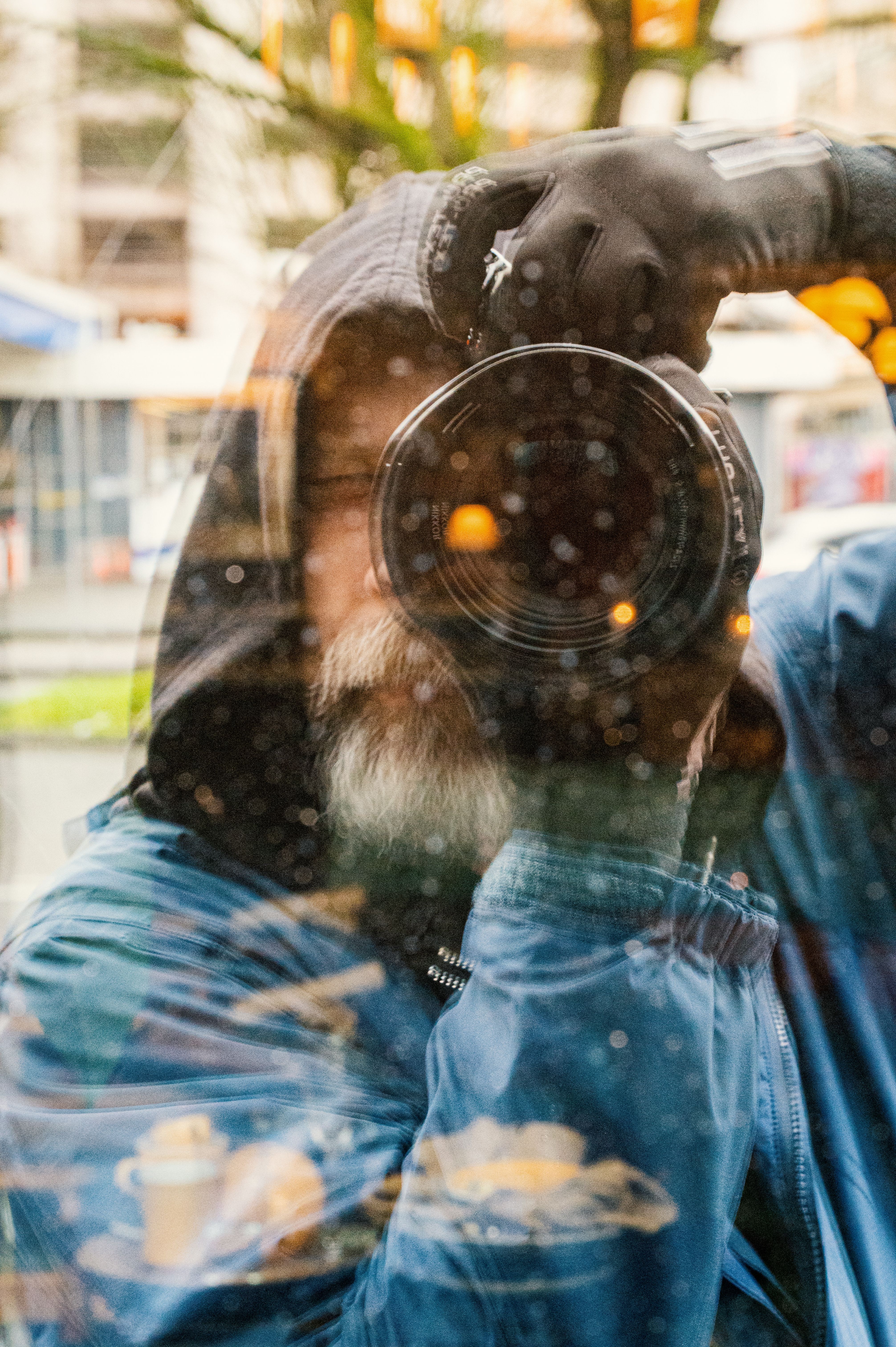 Reflection of a Photographer in a City Building Window · Free Stock Photo