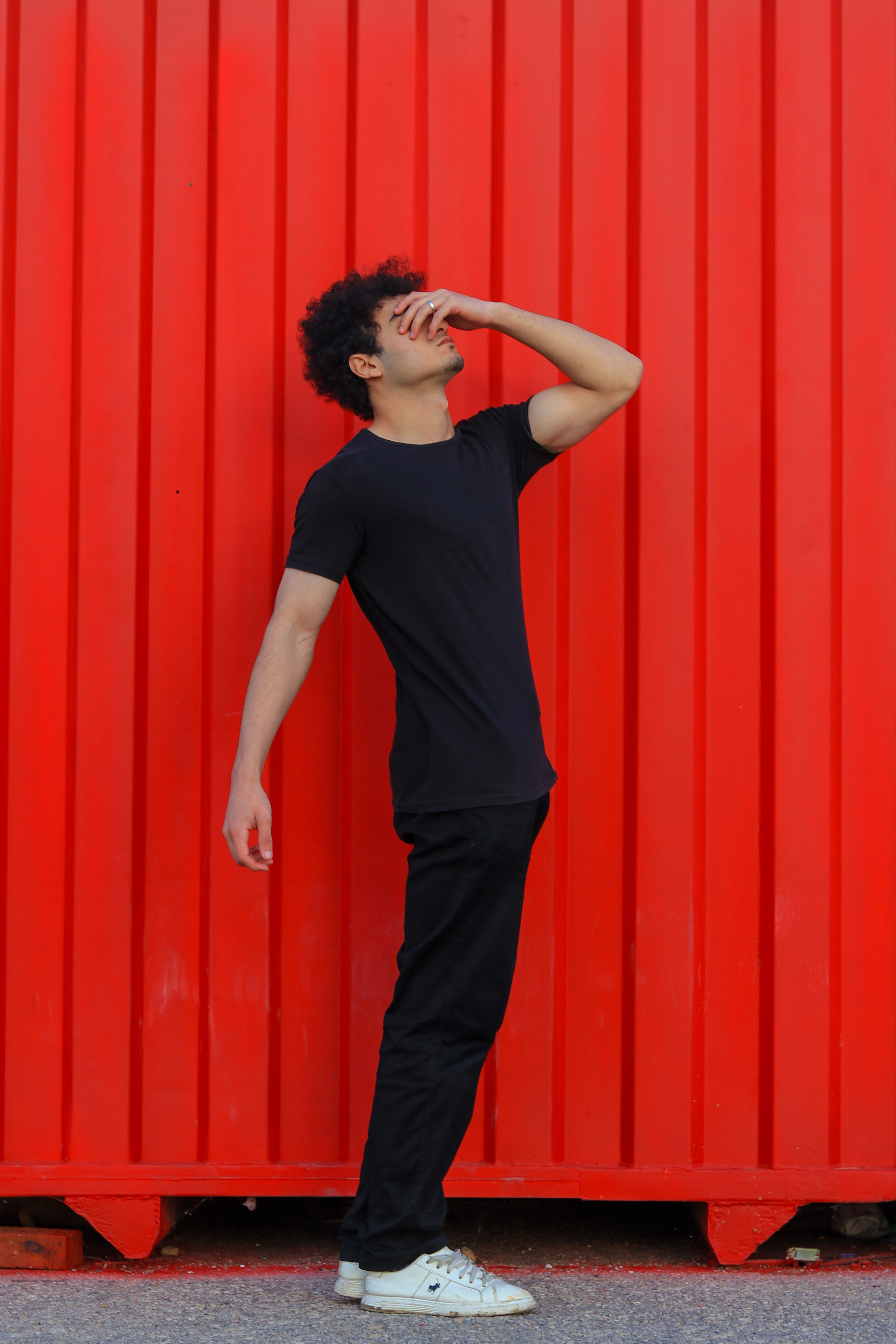 Standing Man in Black by Red Wall · Free Stock Photo