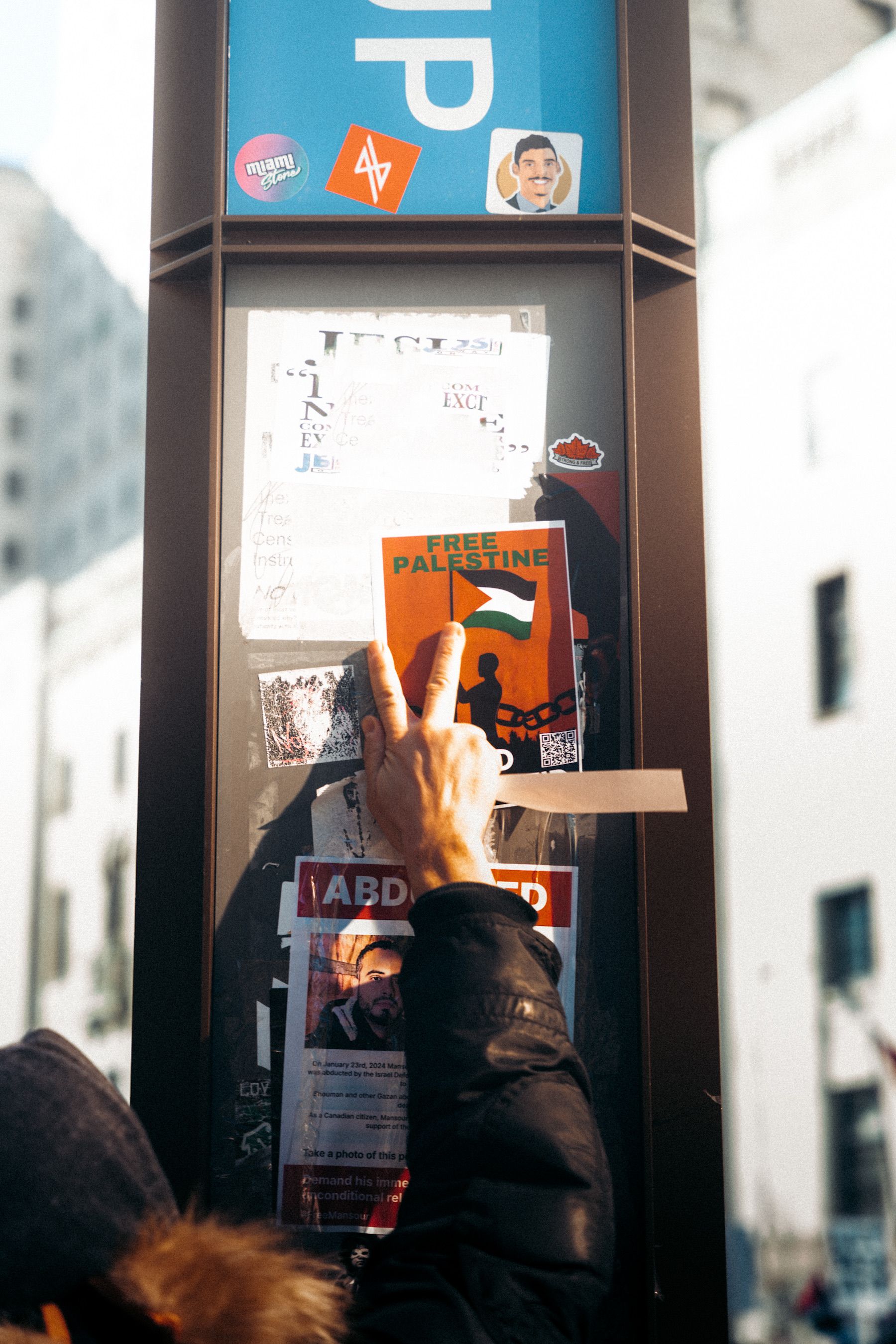 Hand Placing Political Sticker on Pole · Free Stock Photo