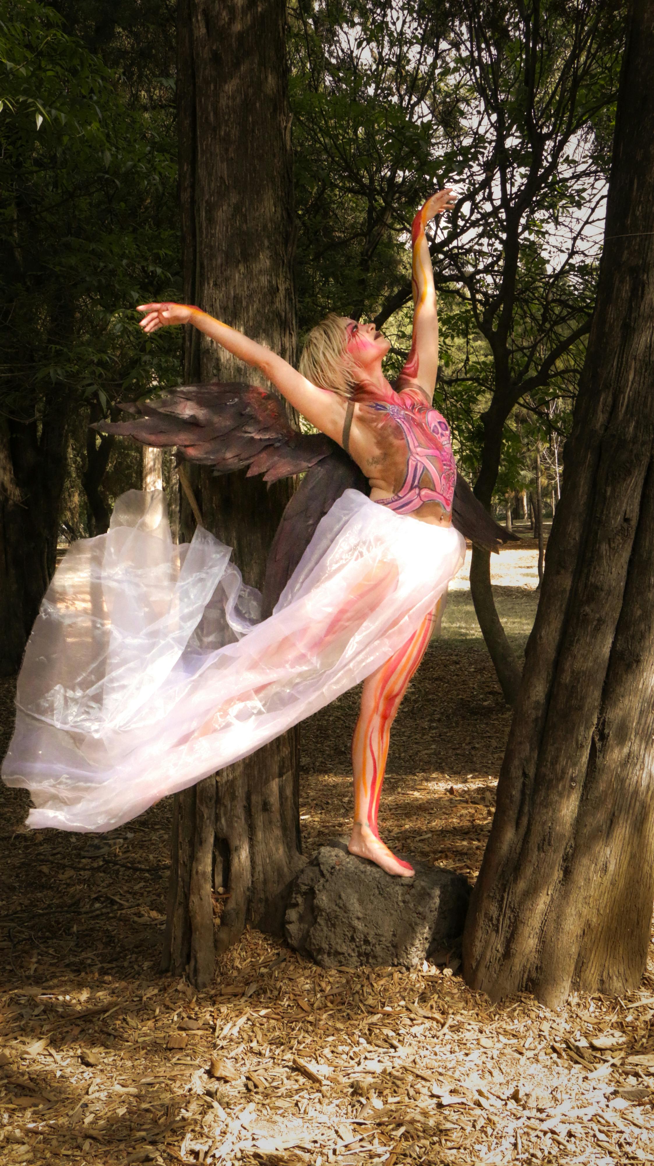 Woman in Cosplay Costume Posing between Trees in Forest · Free Stock Photo