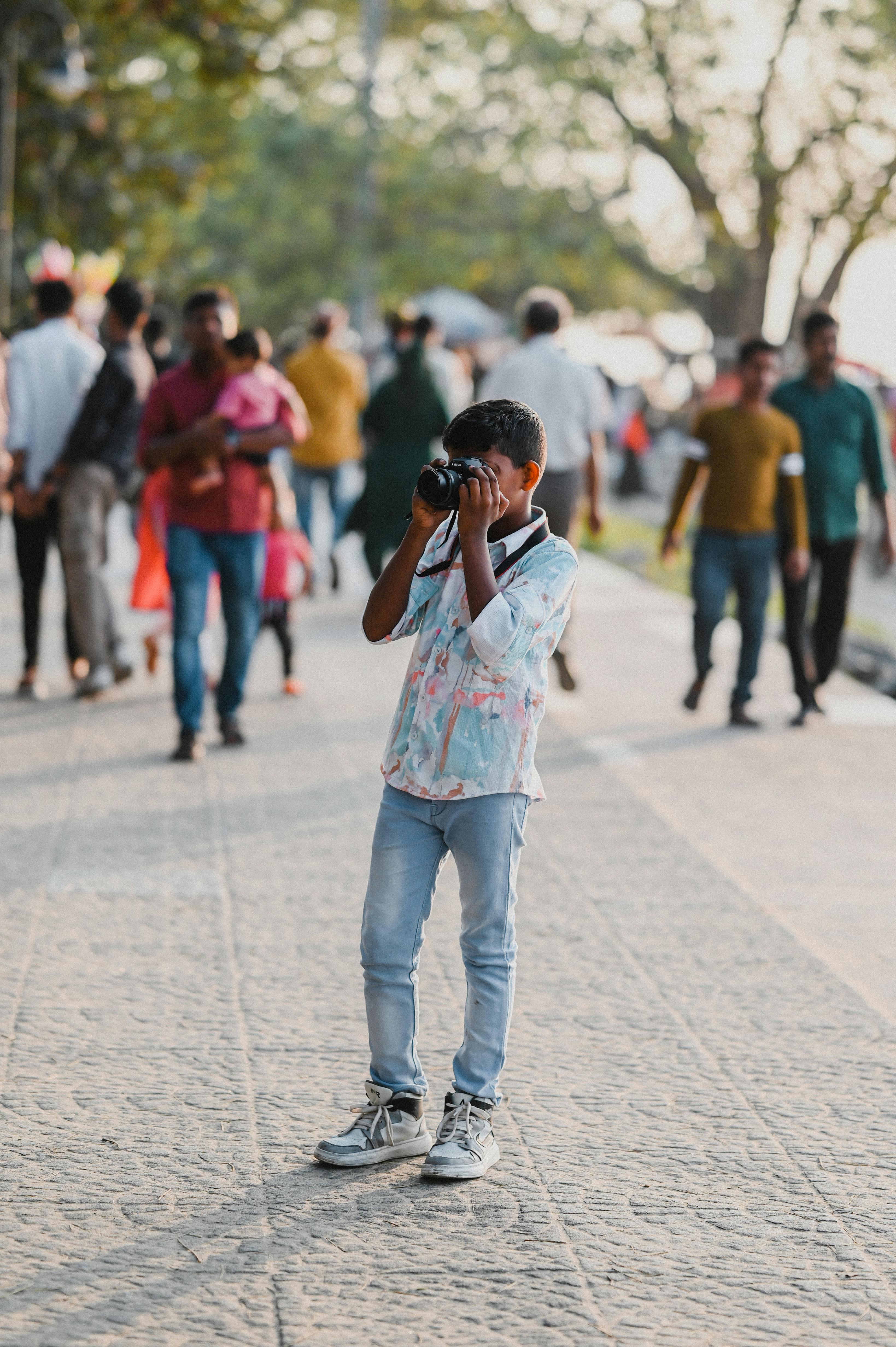 Boy Taking Pictures with Camera on Sidewalk · Free Stock Photo