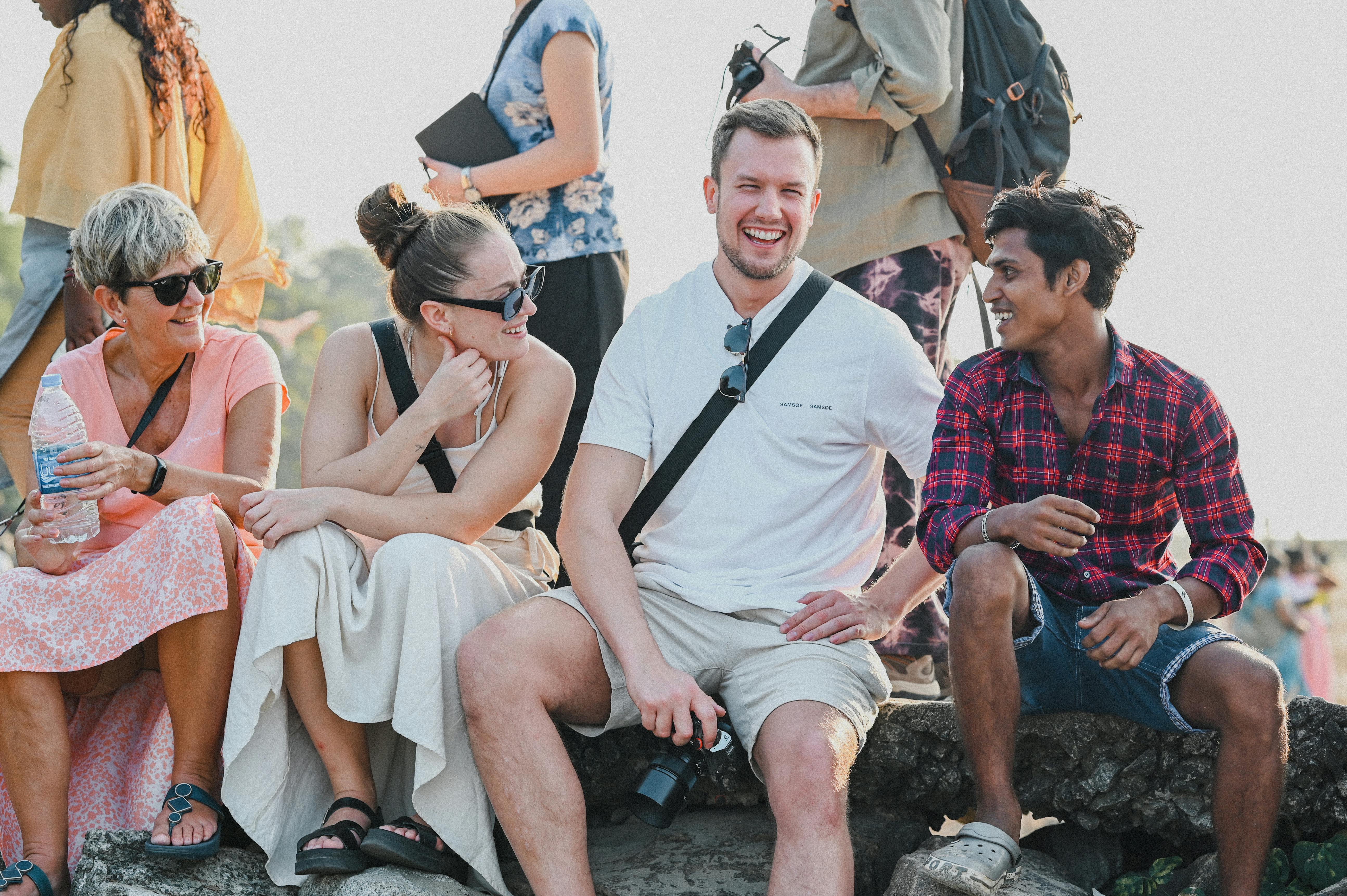 A Group of People Sitting Outside and Smiling · Free Stock Photo