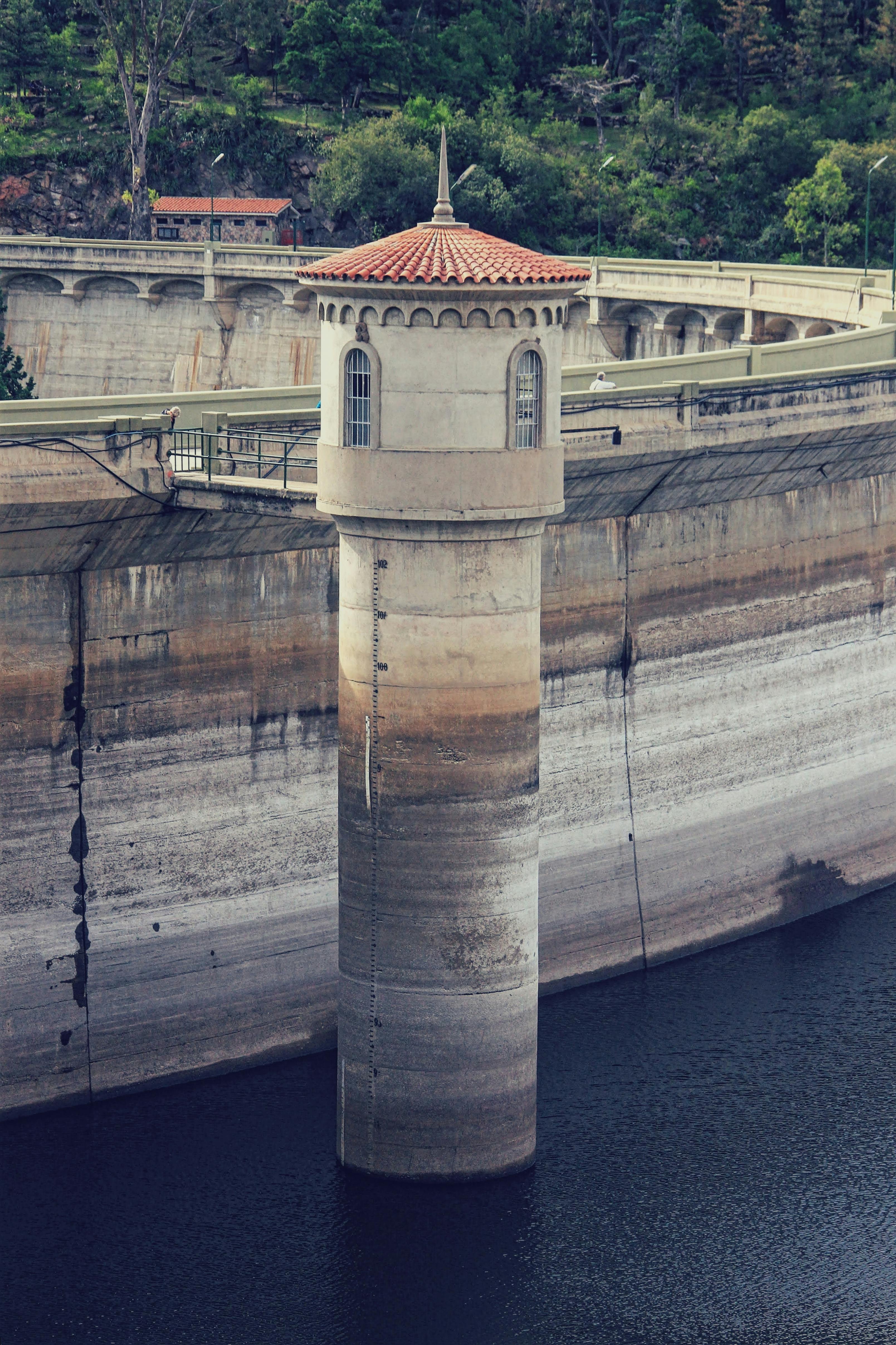 A large concrete dam with a clock tower on top · Free Stock Photo