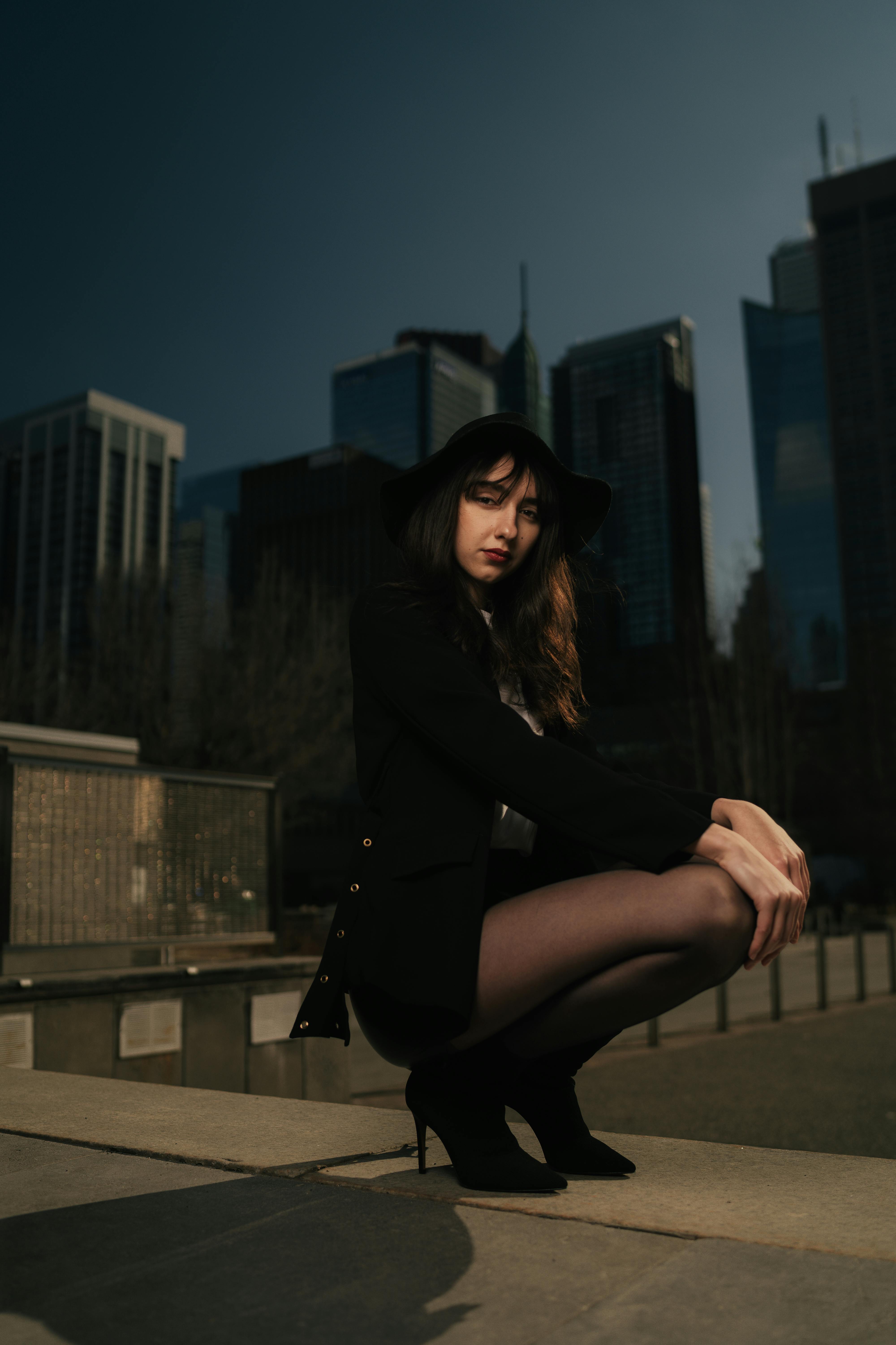 Squatting Posh Model in Black Clothing · Free Stock Photo