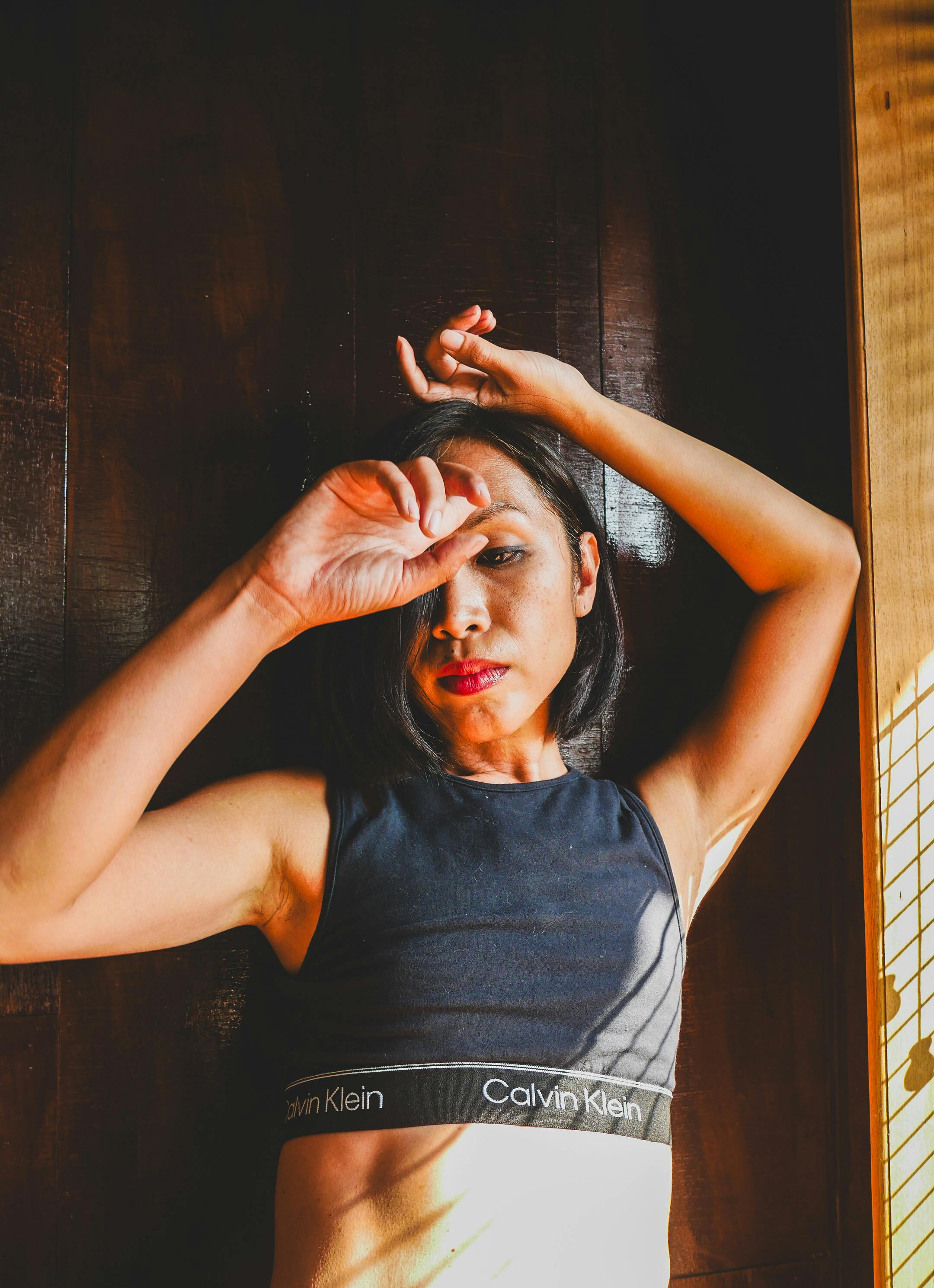 A Woman Standing in Sunlight by the Window · Free Stock Photo