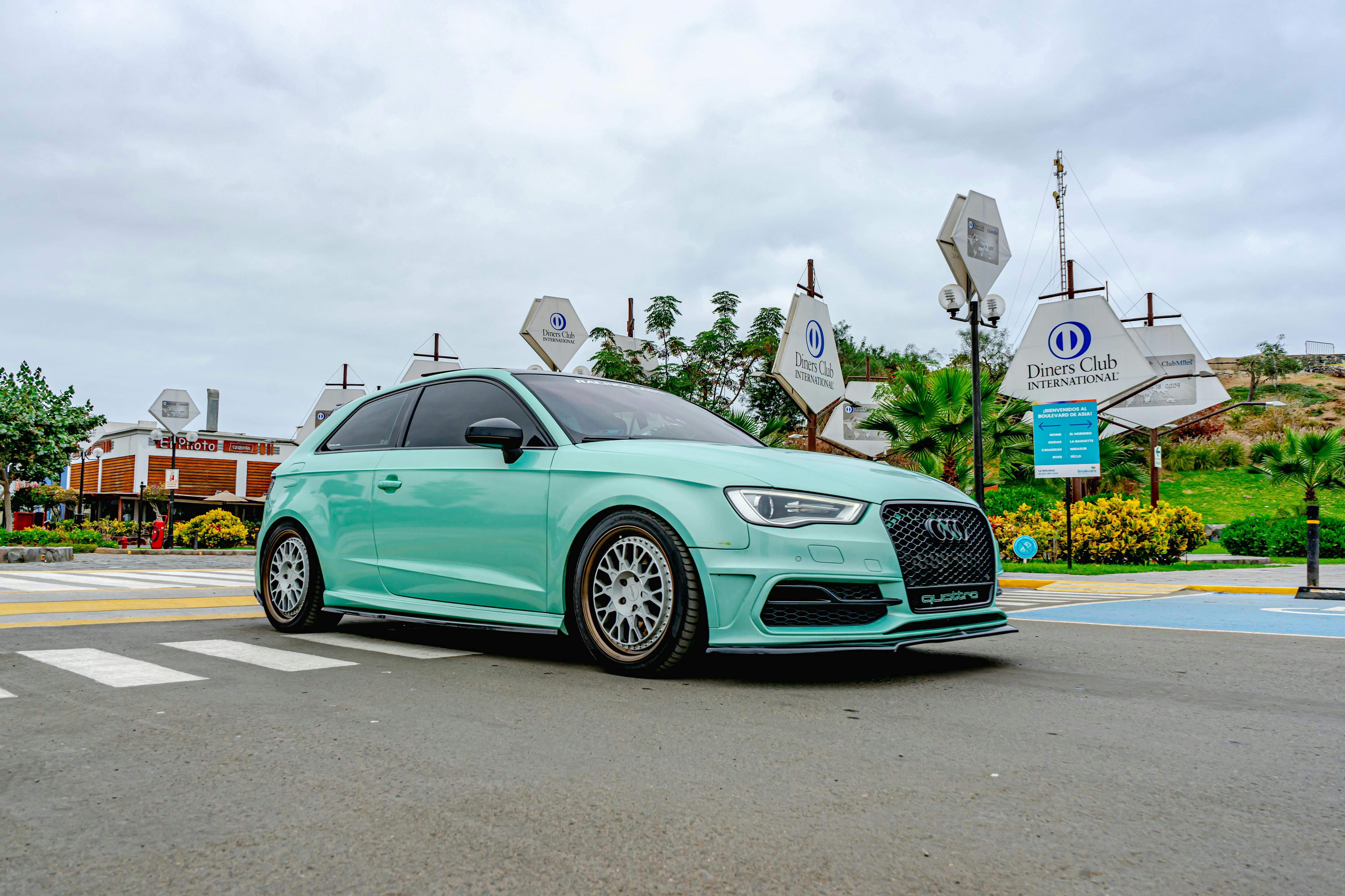 A mint green audi is parked on the road · Free Stock Photo