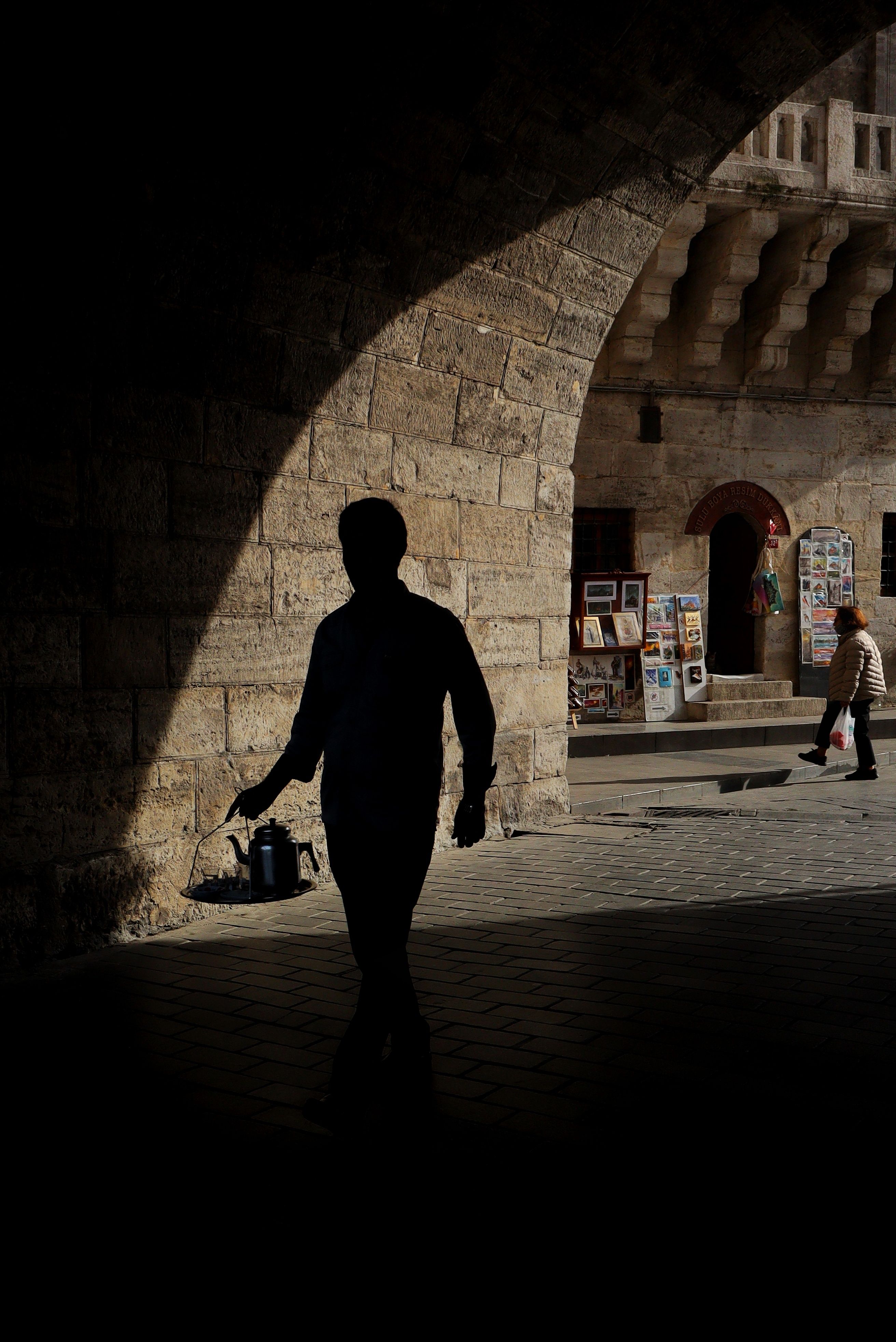 Silhouette of a Man Carrying a Tray with a Coffee Pot and Glasses in ...